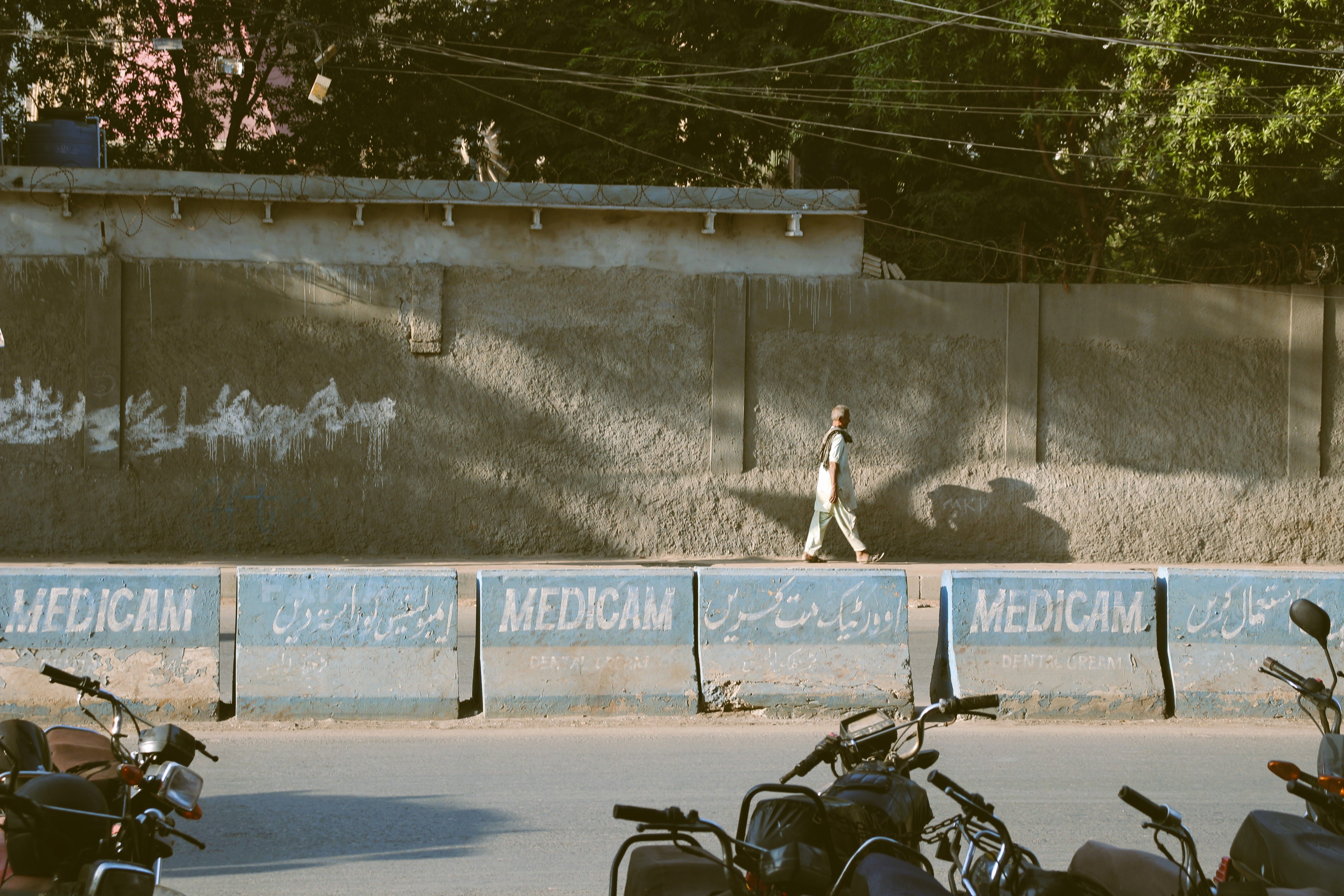 Urban Street Scene with Walking Pedestrian and Shadows · Free Stock Photo