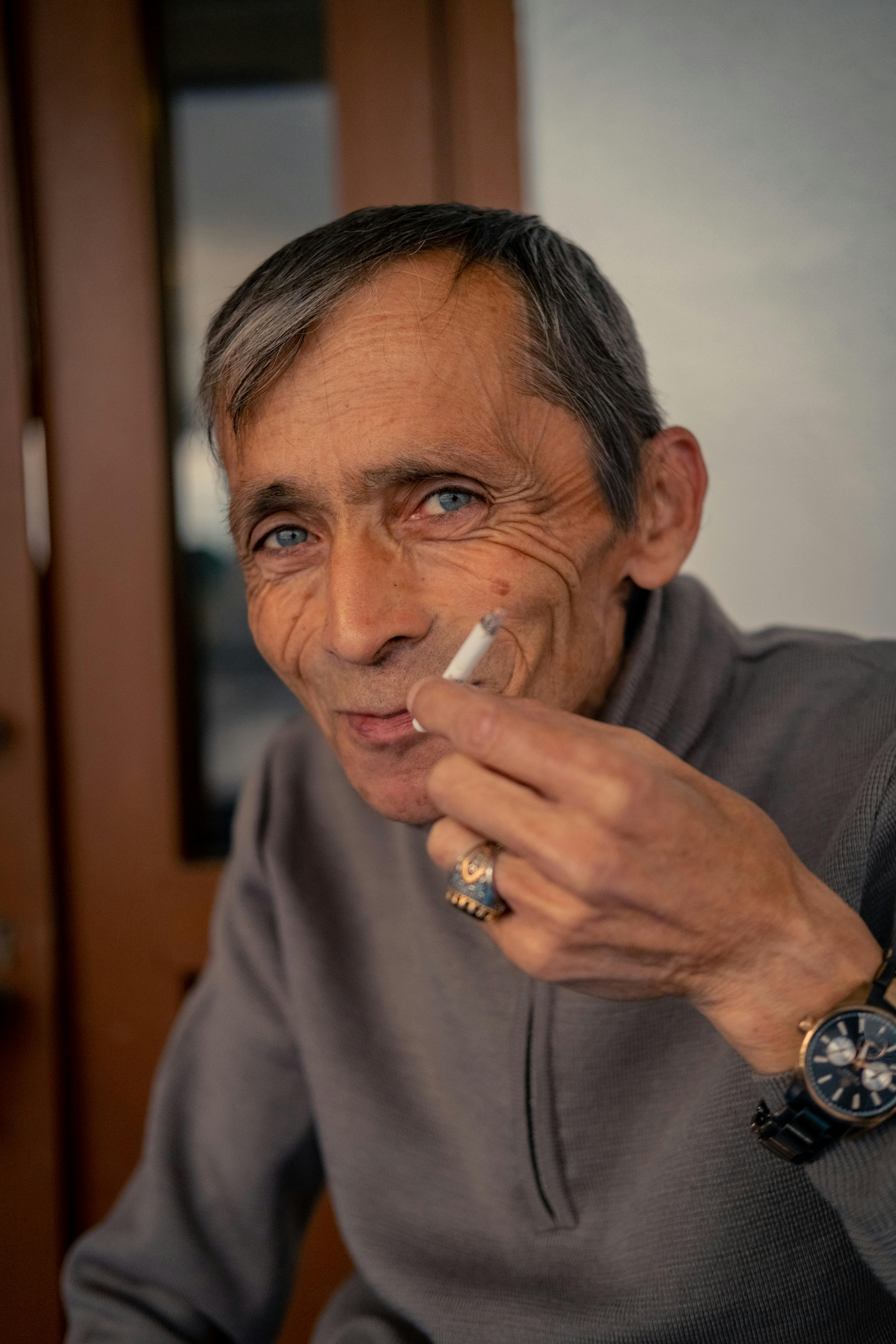 Senior Man Enjoying Cigarette Indoors · Free Stock Photo