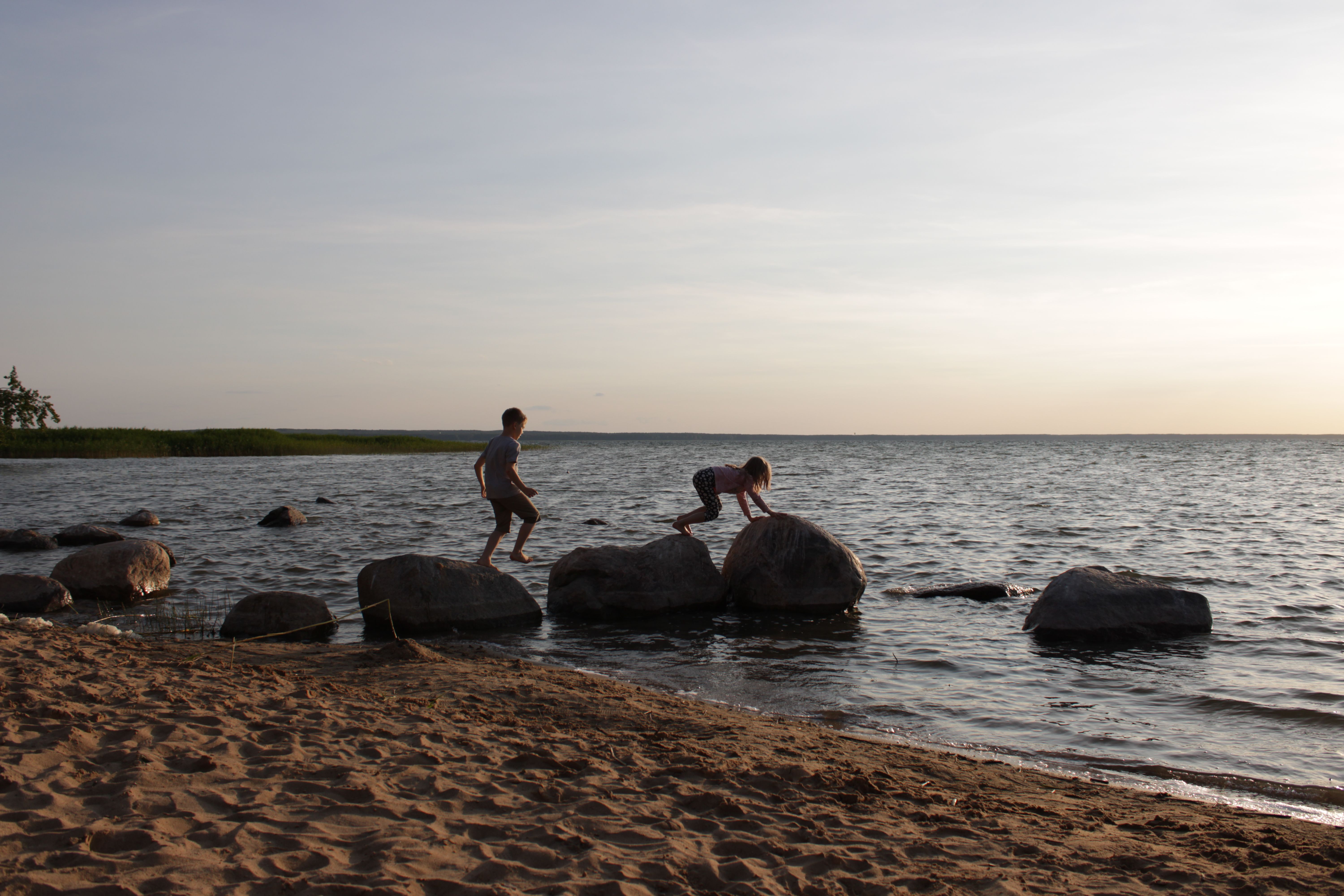 Children Playing on Rocks at Sandy Beach Sunset · Free Stock Photo