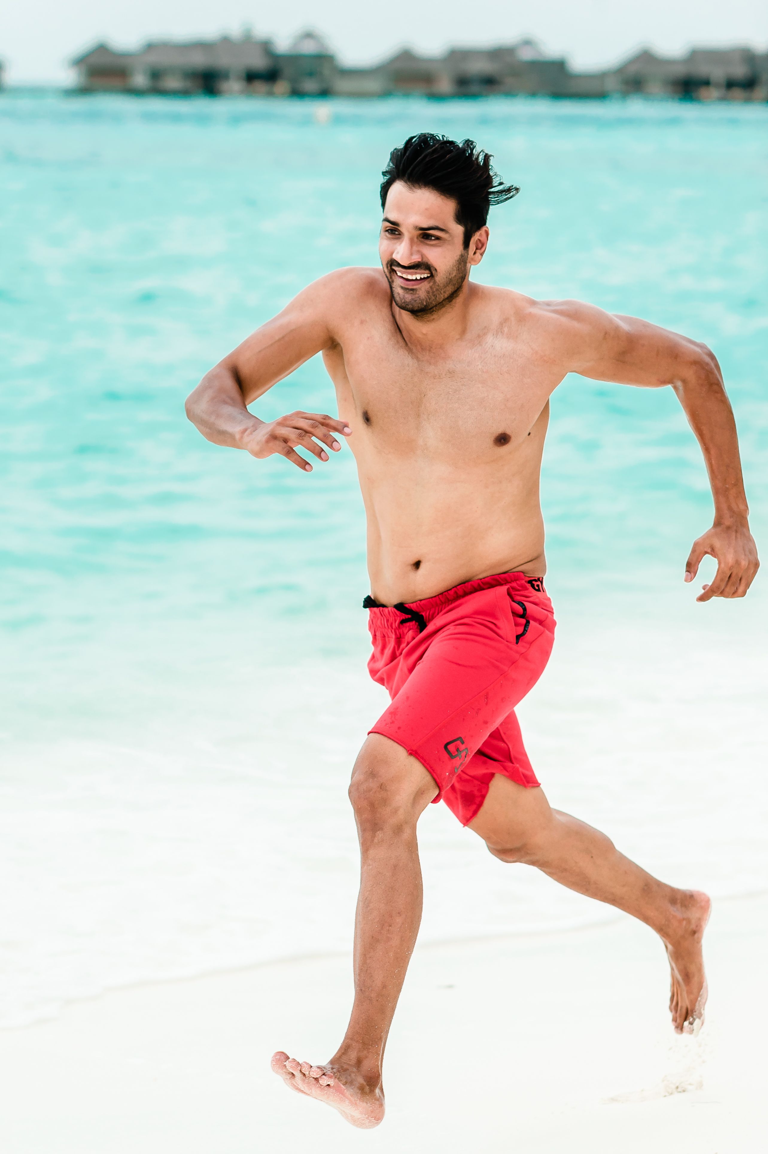 Smiling Man Running on Maldives Beach · Free Stock Photo