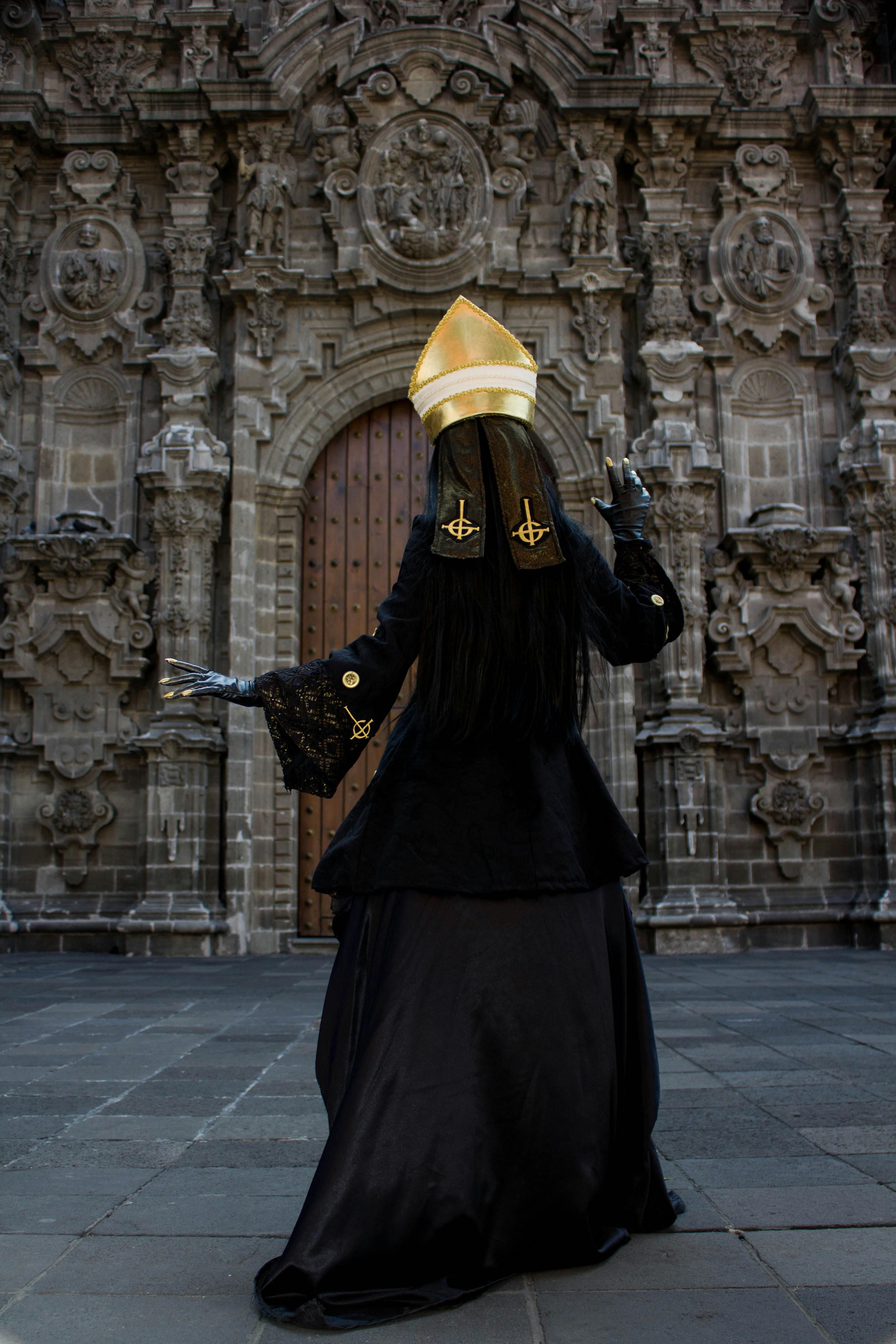 Gothic Figure in Robes Facing Ornate Church · Free Stock Photo