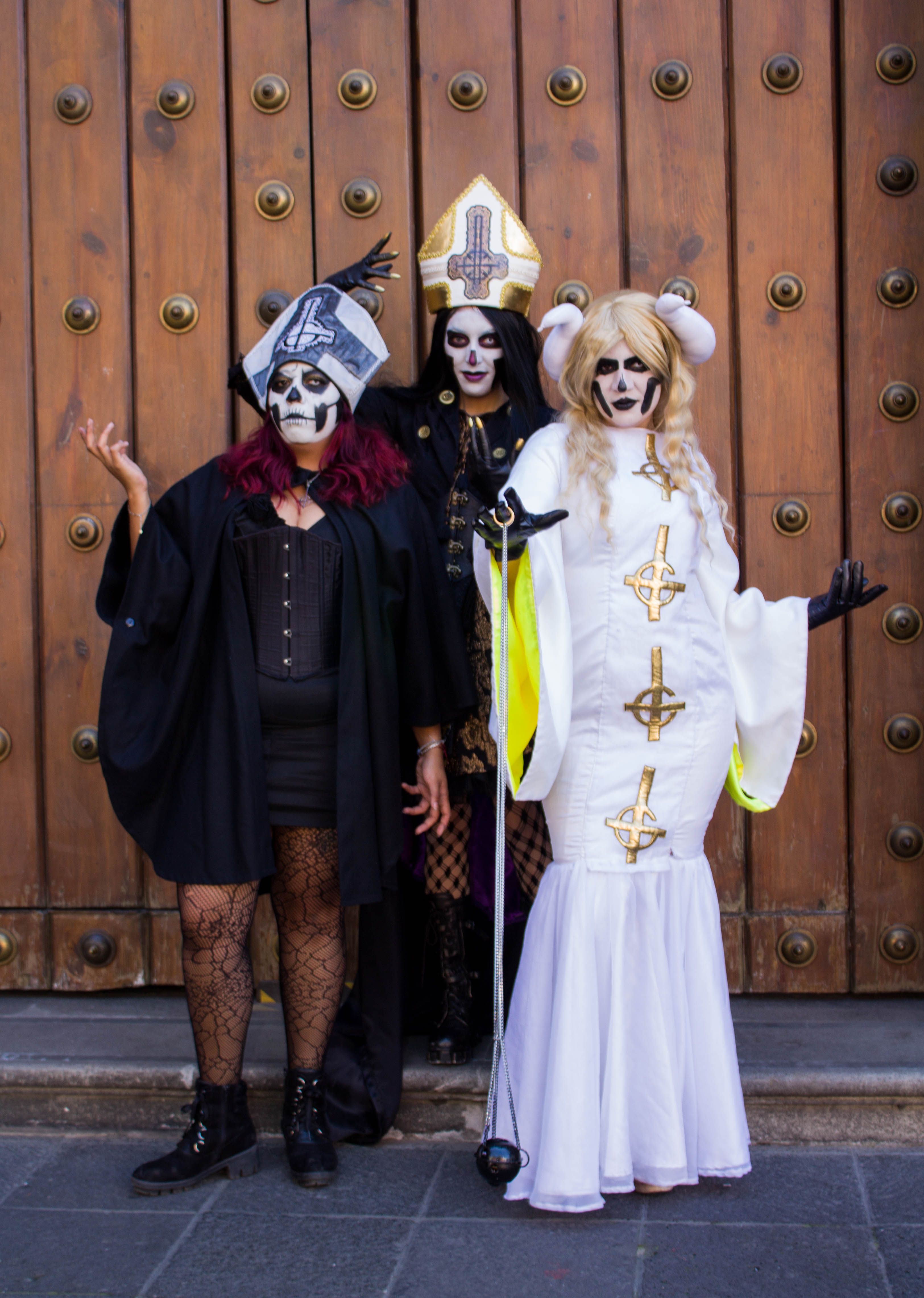Three People in Gothic Costumes by Wooden Door · Free Stock Photo