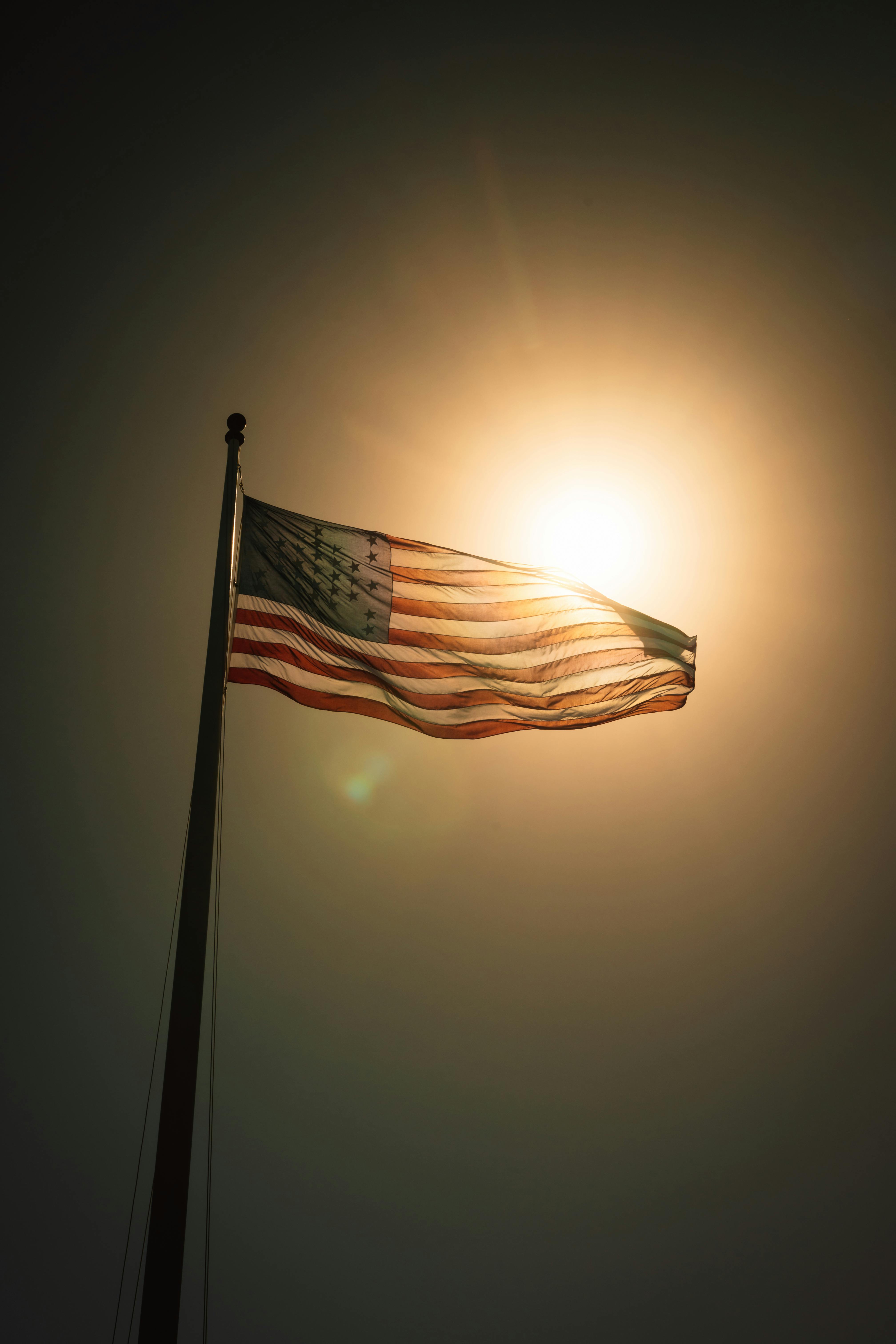 USA Flag Backlit by Sunlight with Flare · Free Stock Photo