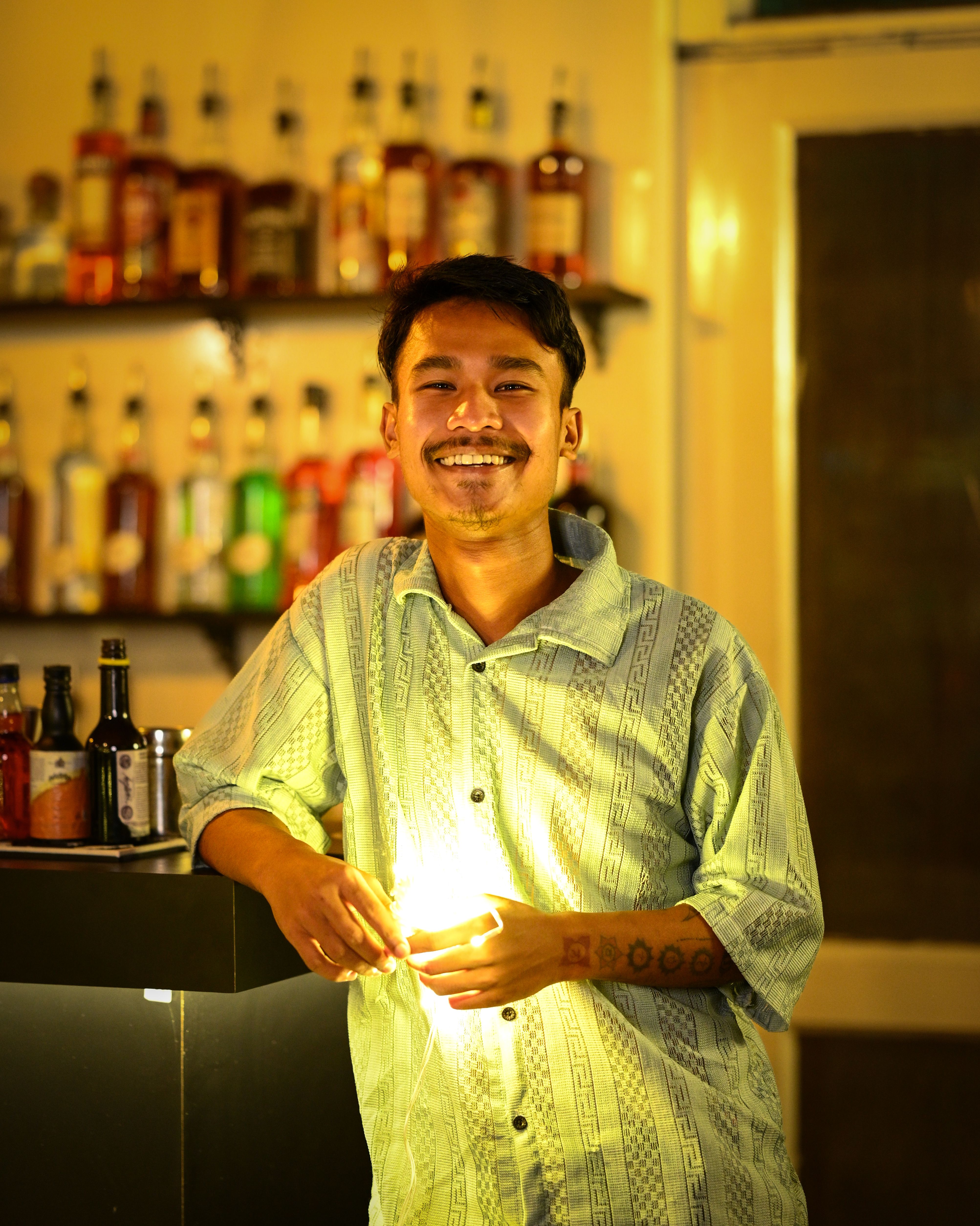 Smiling Bartender in Indian Bar Setting · Free Stock Photo