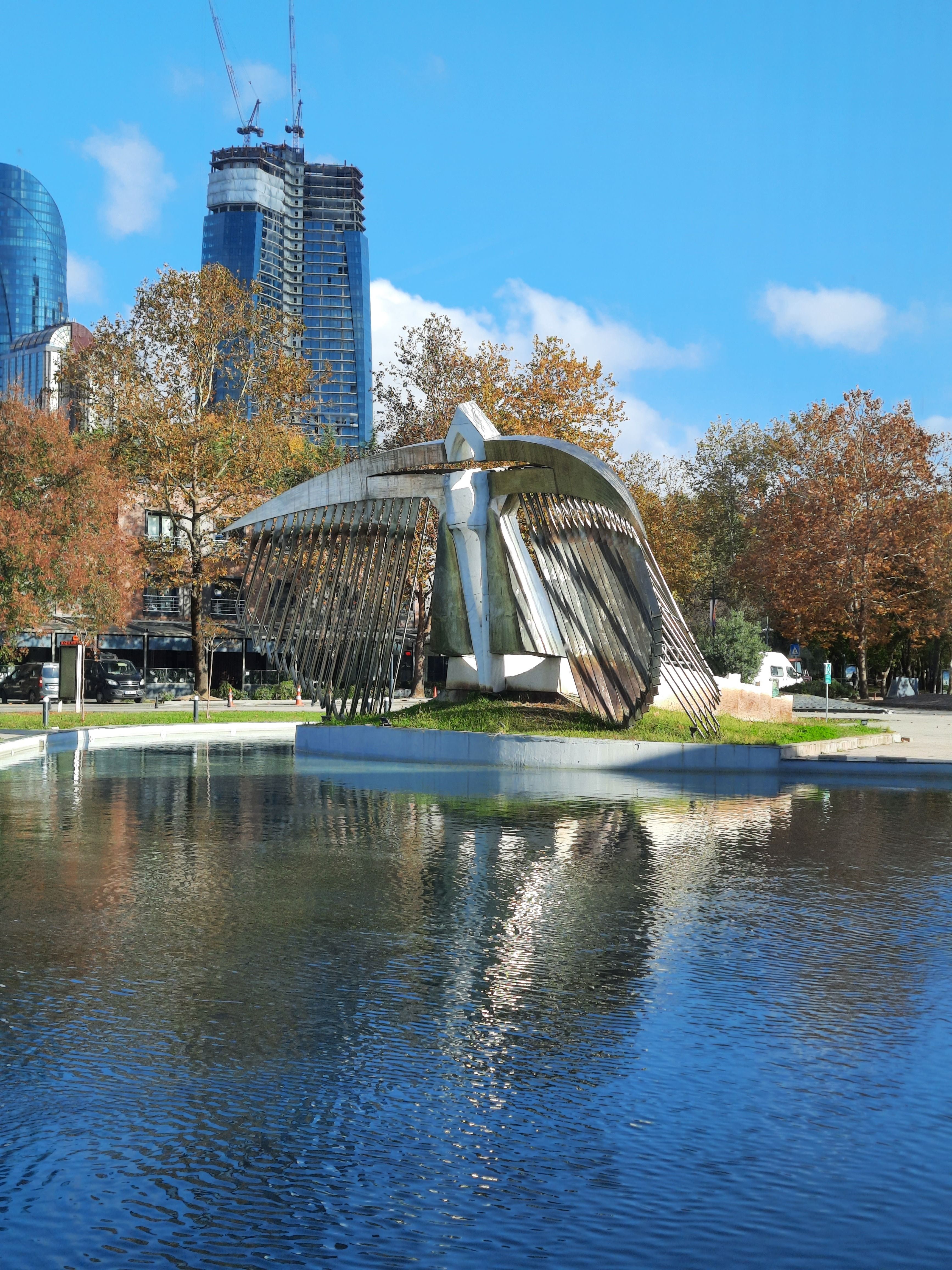 Modern Sculpture in Urban Park Reflecting Pond · Free Stock Photo