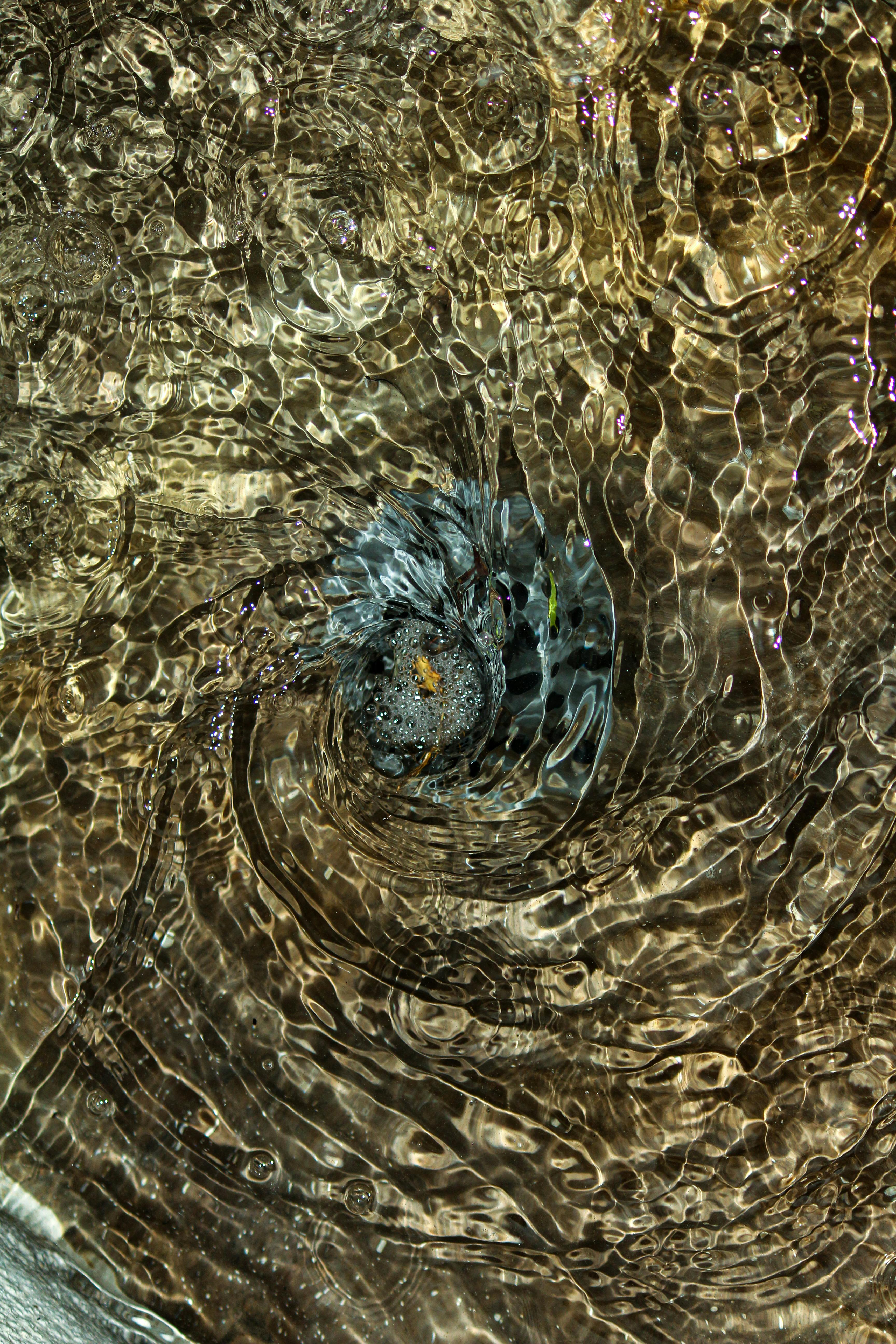 Vortex in Rippling Water with Light Reflections · Free Stock Photo