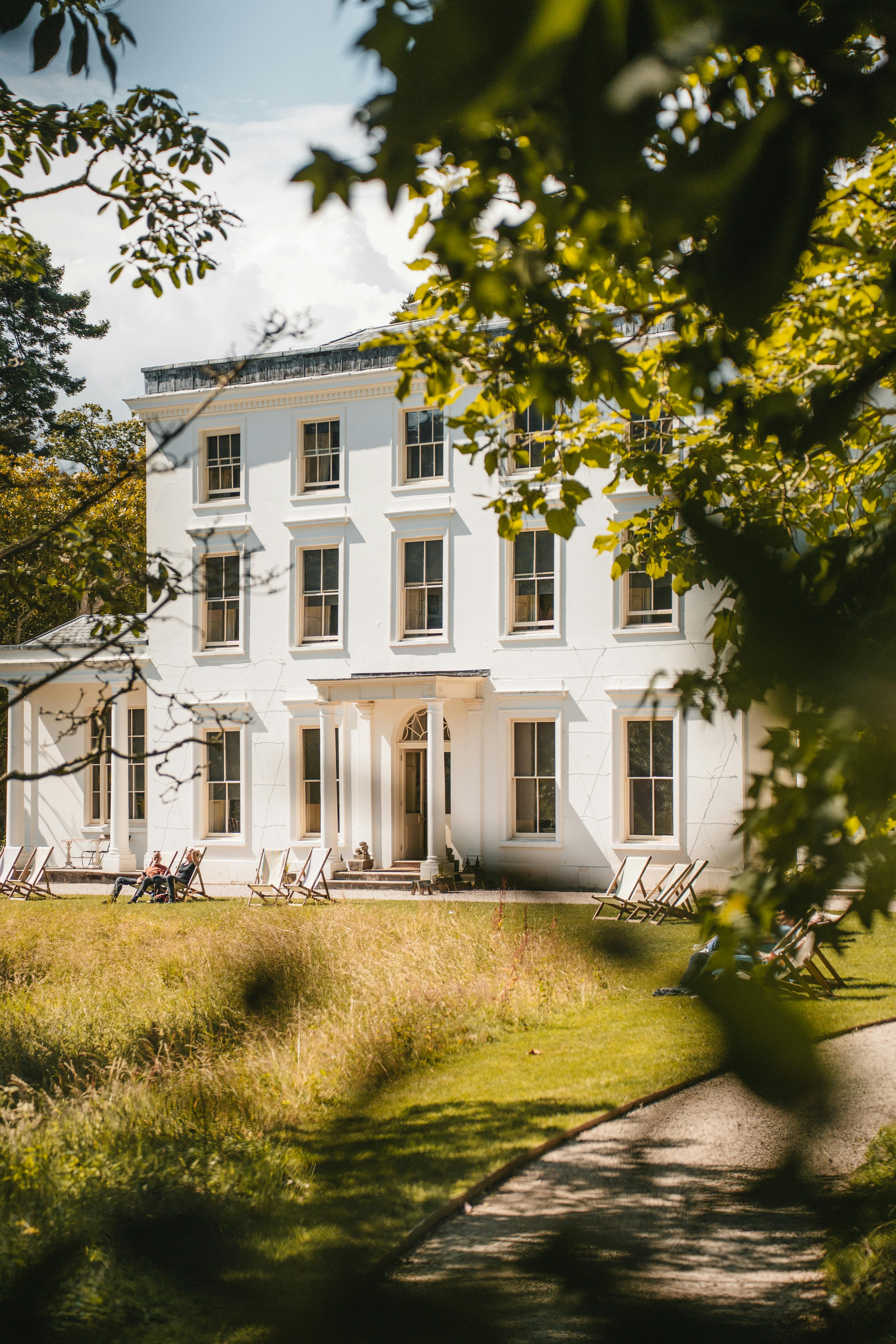 Stately White Mansion Surrounded by Lush Greenery · Free Stock Photo