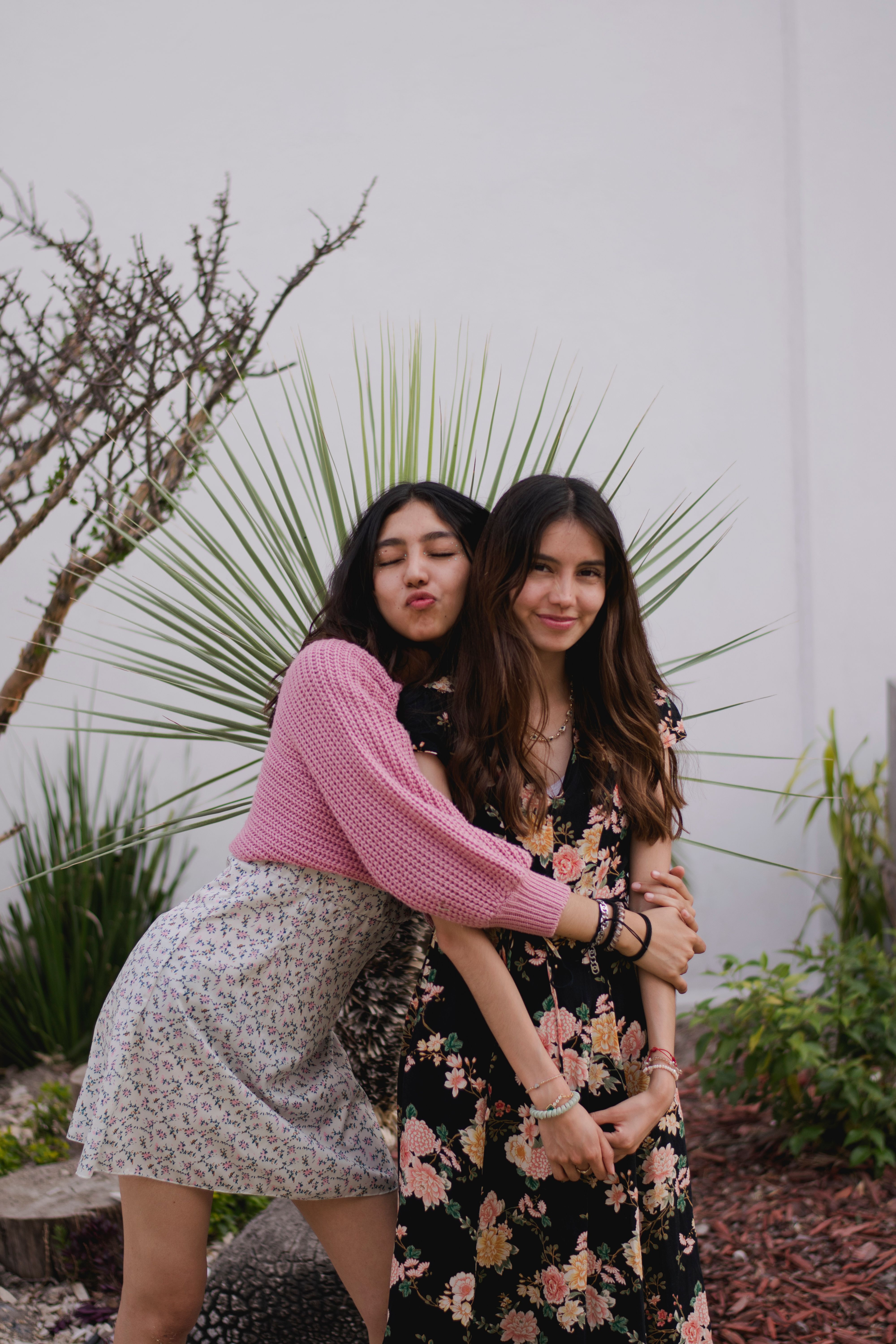 Two Friends Posing Playfully in a Garden · Free Stock Photo
