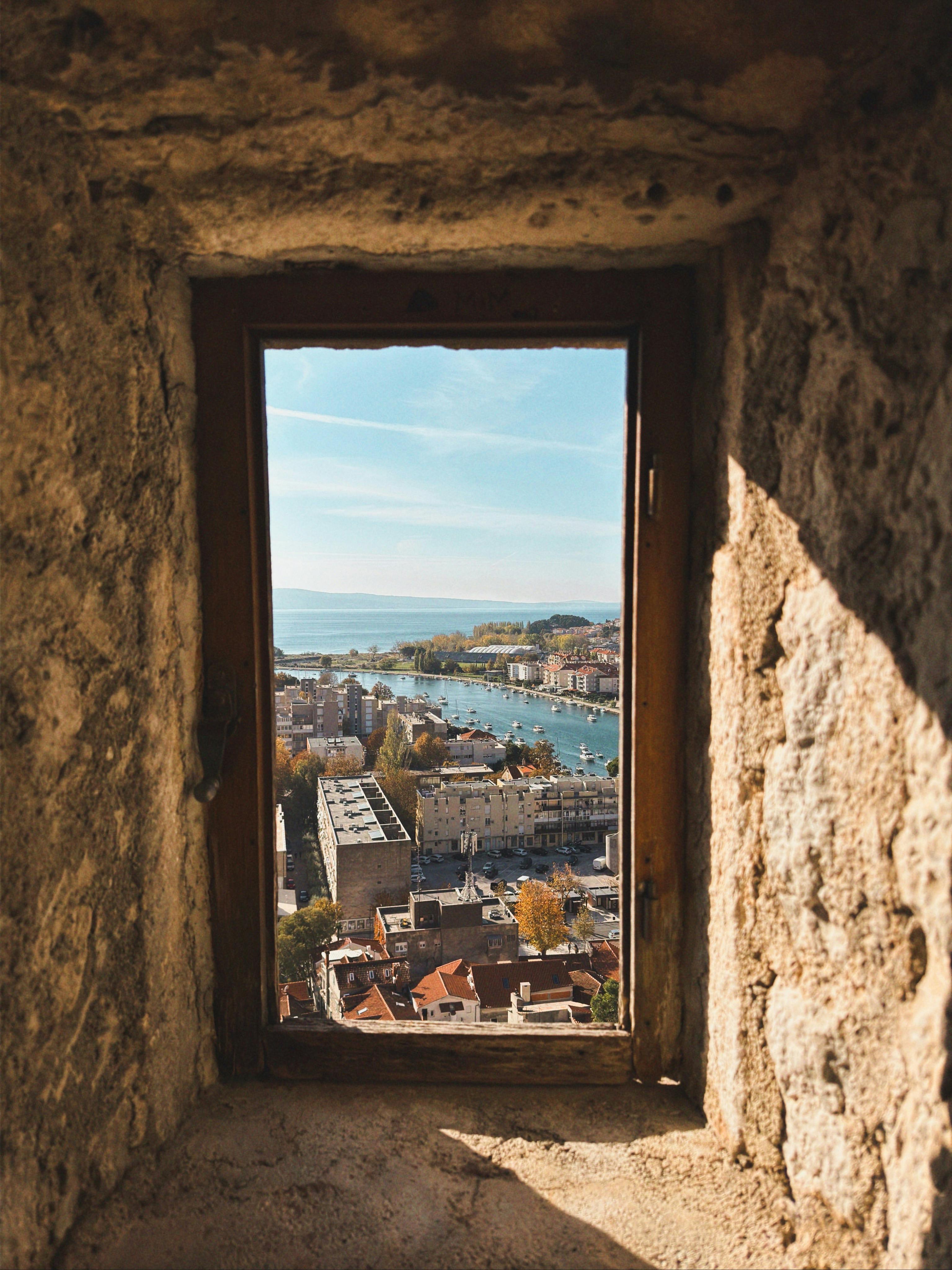 Scenic Cityscape Through Ancient Window Frame · Free Stock Photo