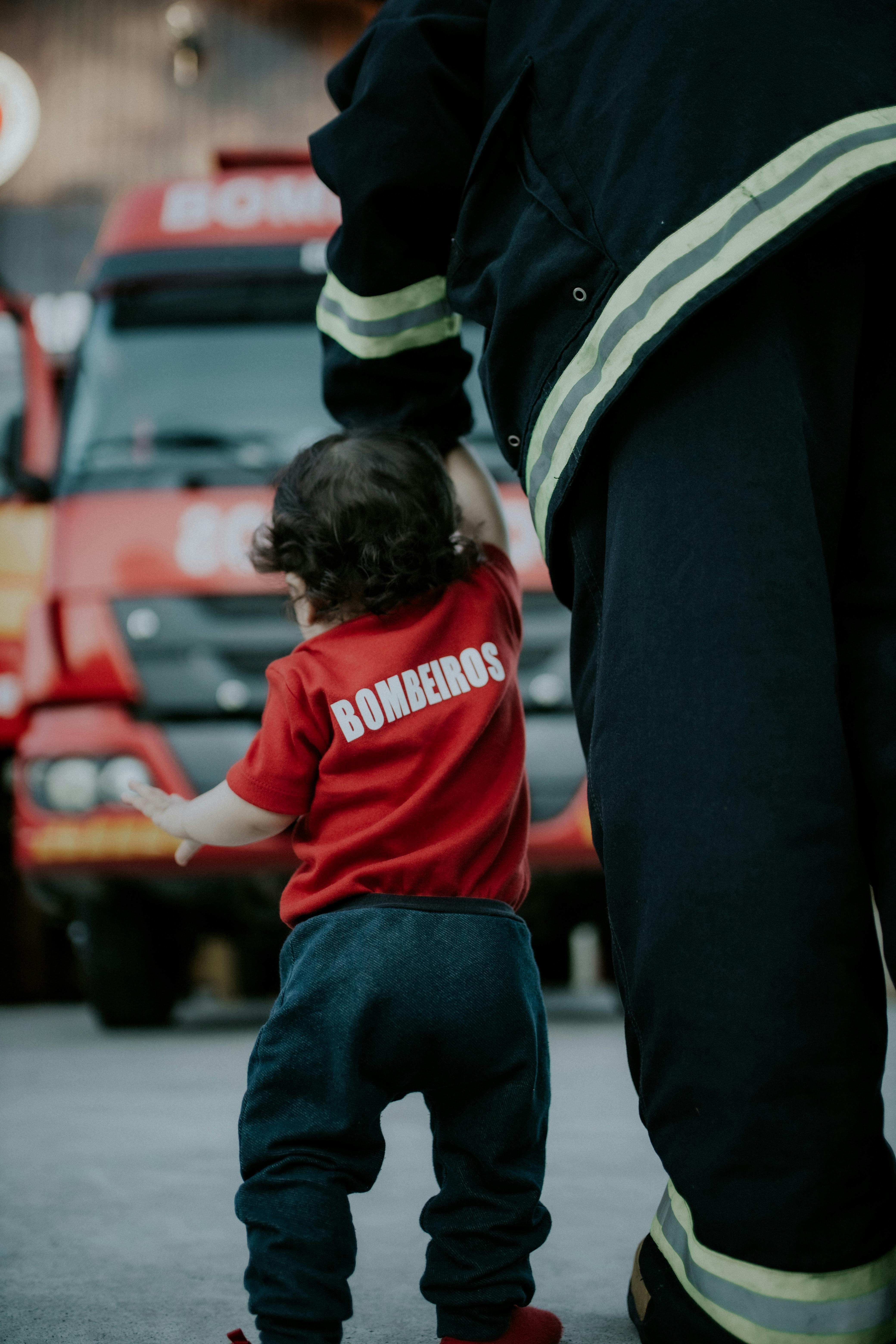 Firefighter with Child at Fire Station · Free Stock Photo