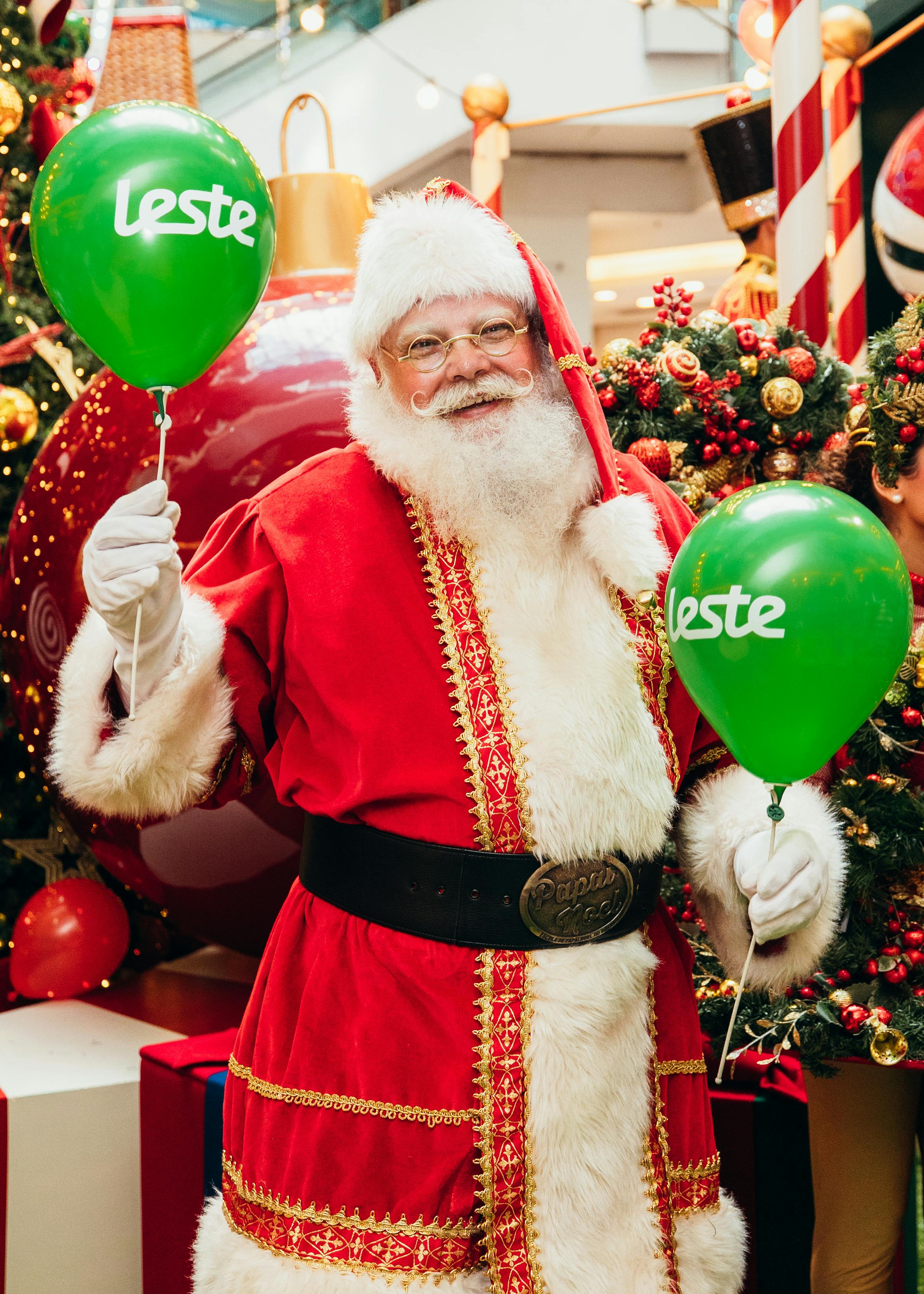 Santa Claus Holding Green Balloons at Christmas Event · Free Stock Photo