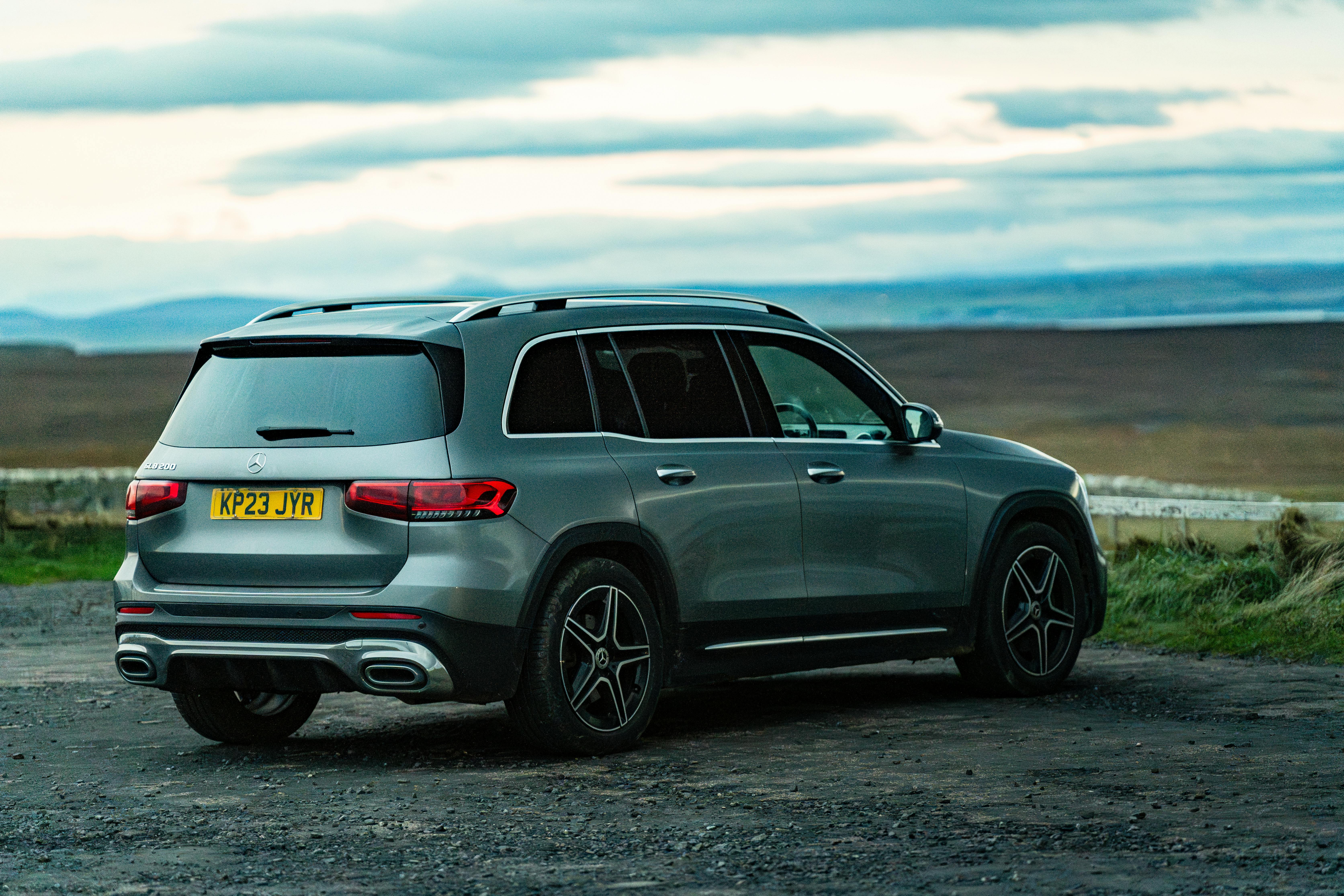 Silver SUV parked on rural road with scenic view · Free Stock Photo
