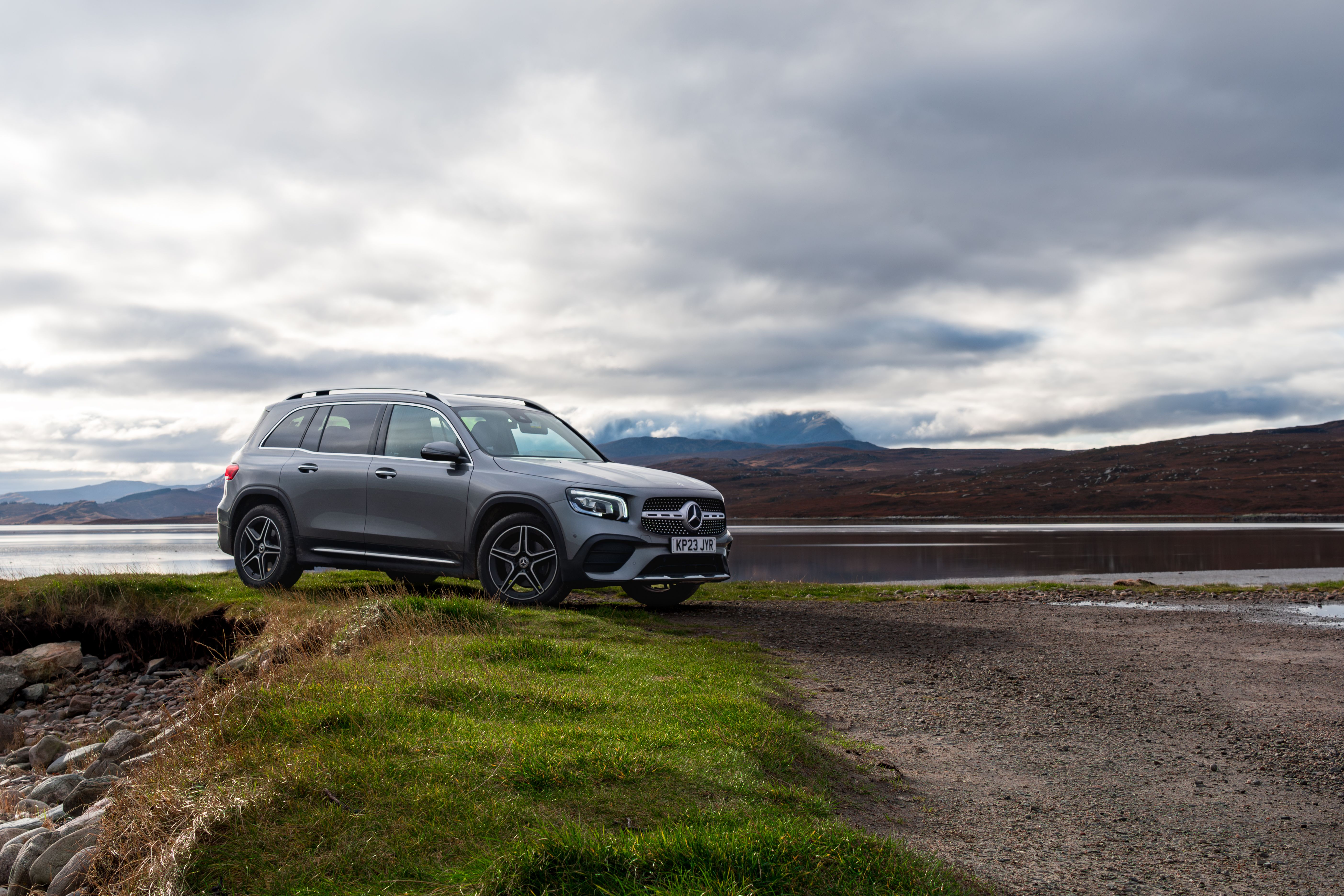 SUV Parked By Scenic Lake Under Cloudy Sky · Free Stock Photo