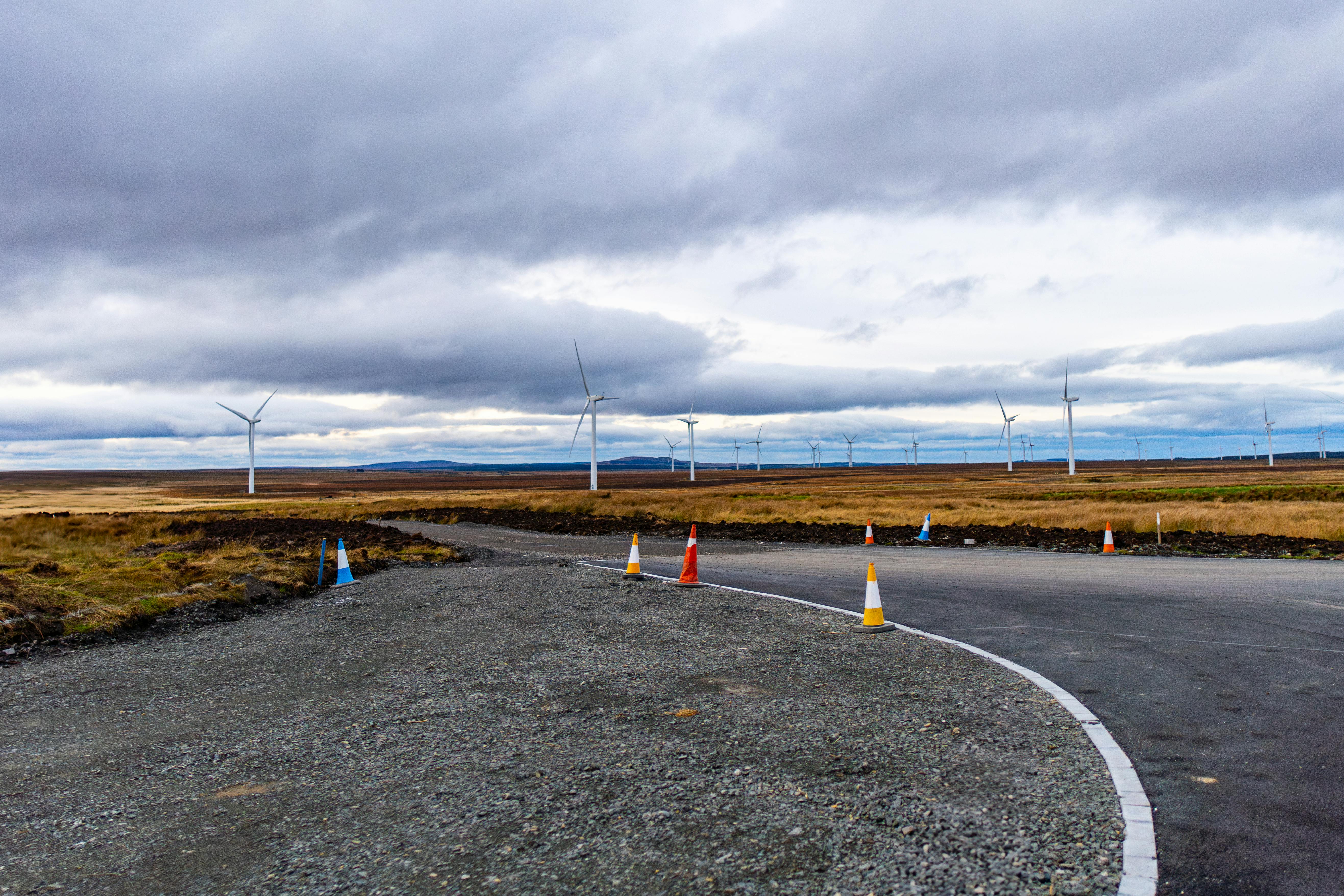 Wind Farm Landscape with Cloudy Sky and Empty Road · Free Stock Photo