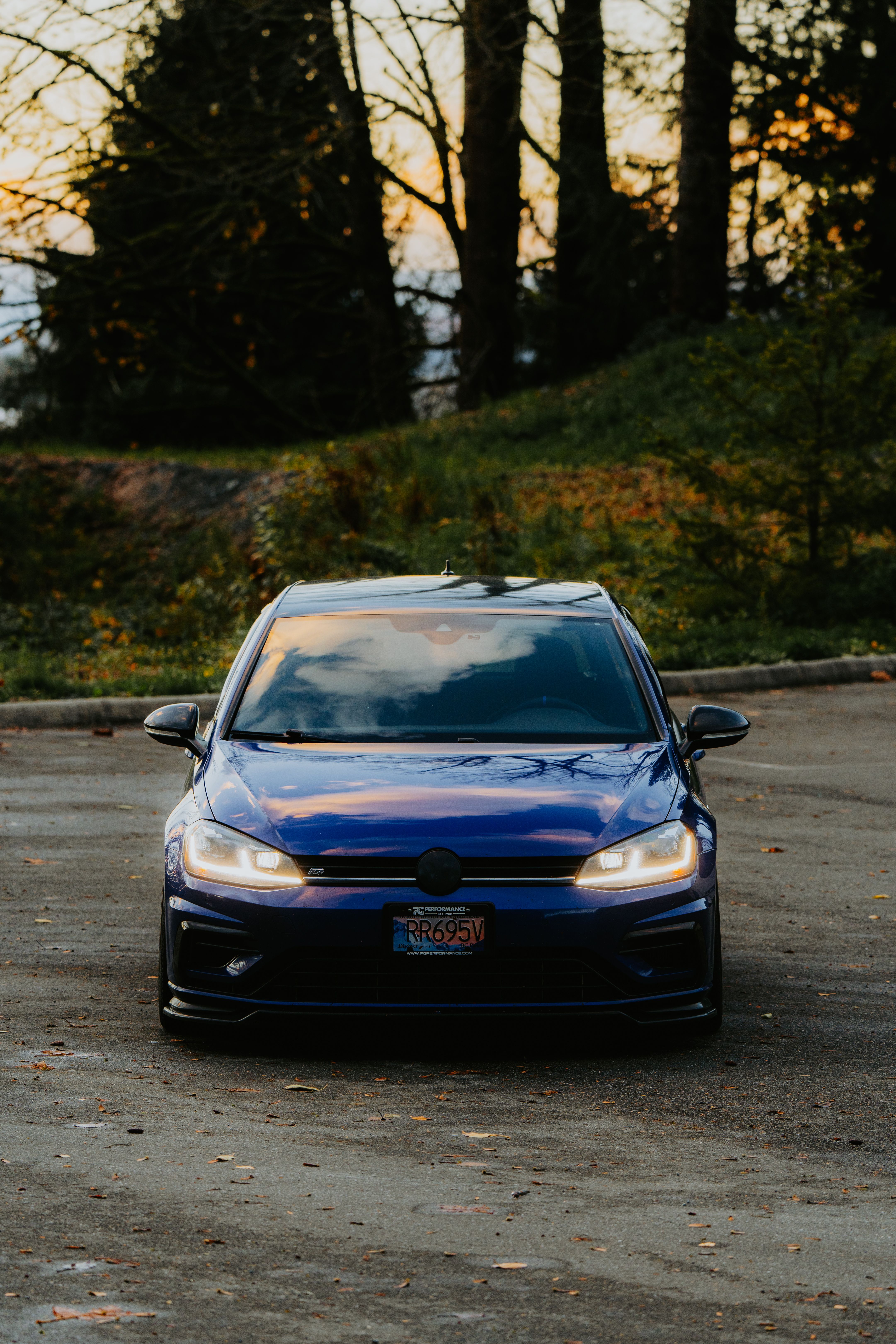 Blue Car at Sunset in Forested Parking Lot · Free Stock Photo