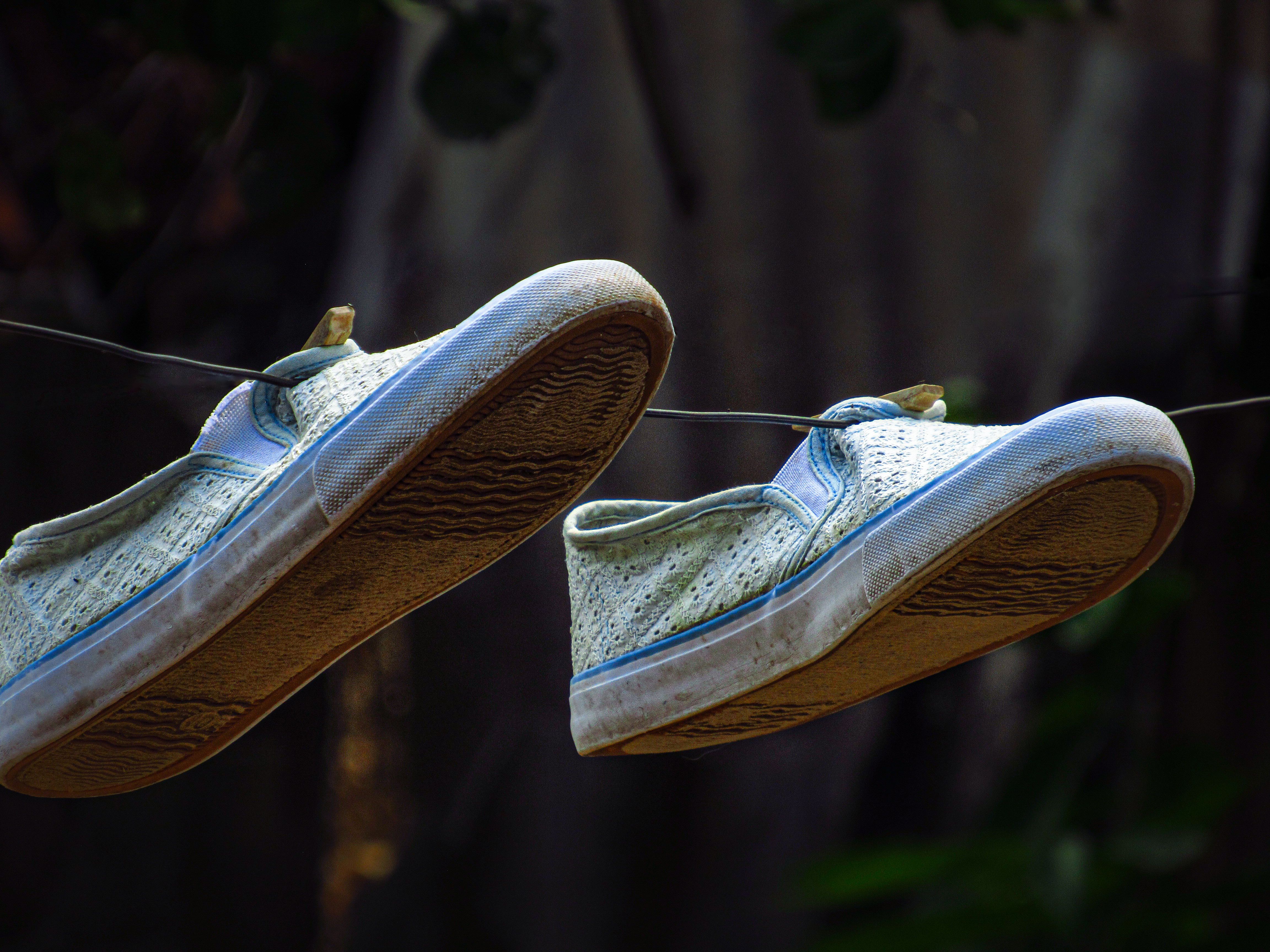 Hanging Worn Canvas Shoes on a Wire Outdoors · Free Stock Photo