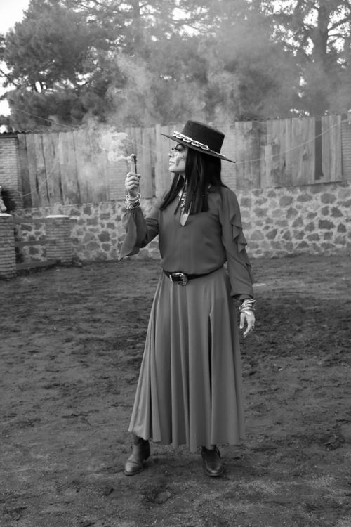 Woman in Western Attire Holding Smoking Gun · Free Stock Photo