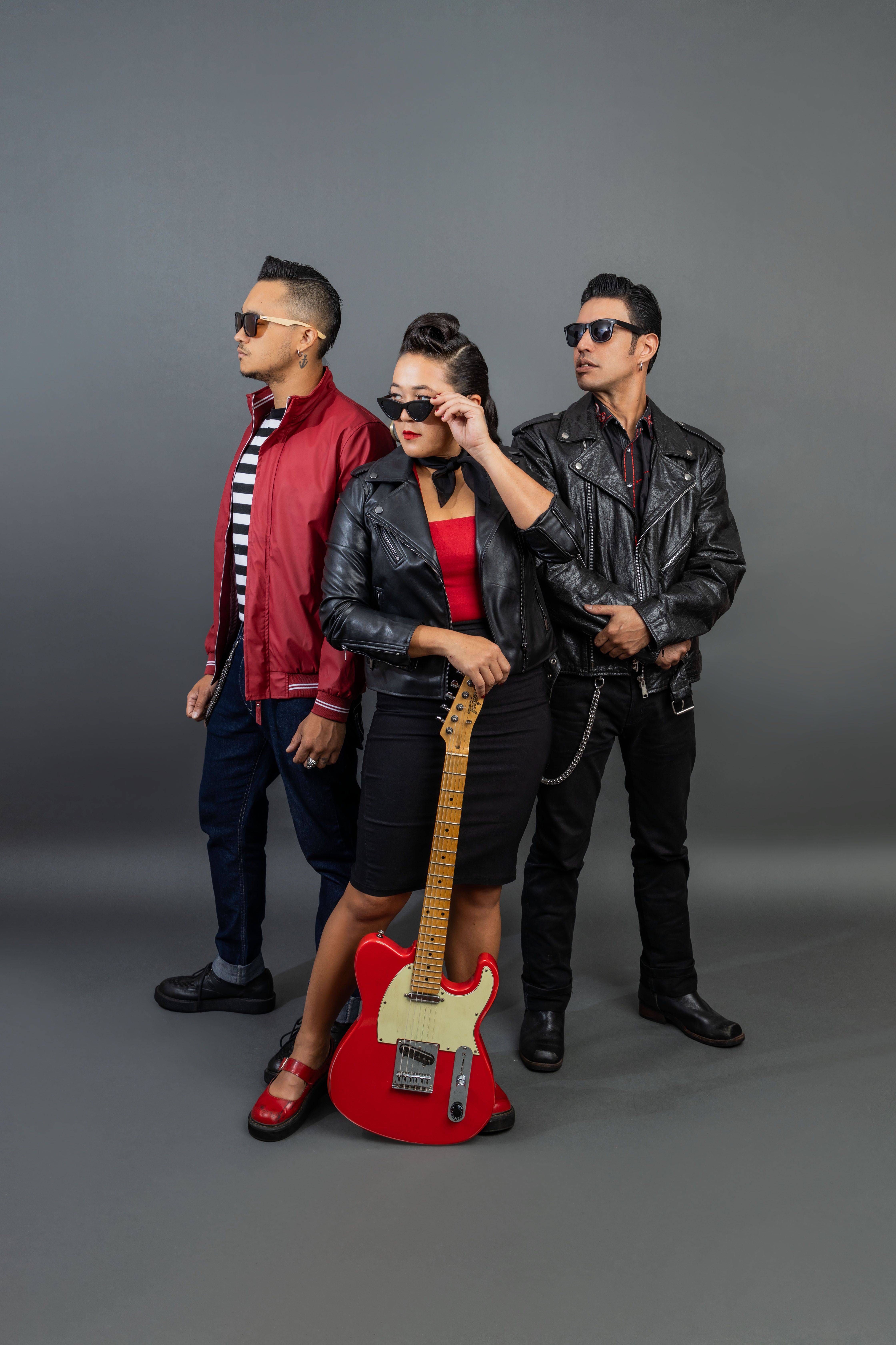 Trendy Band Posing with Electric Guitar in Studio · Free Stock Photo