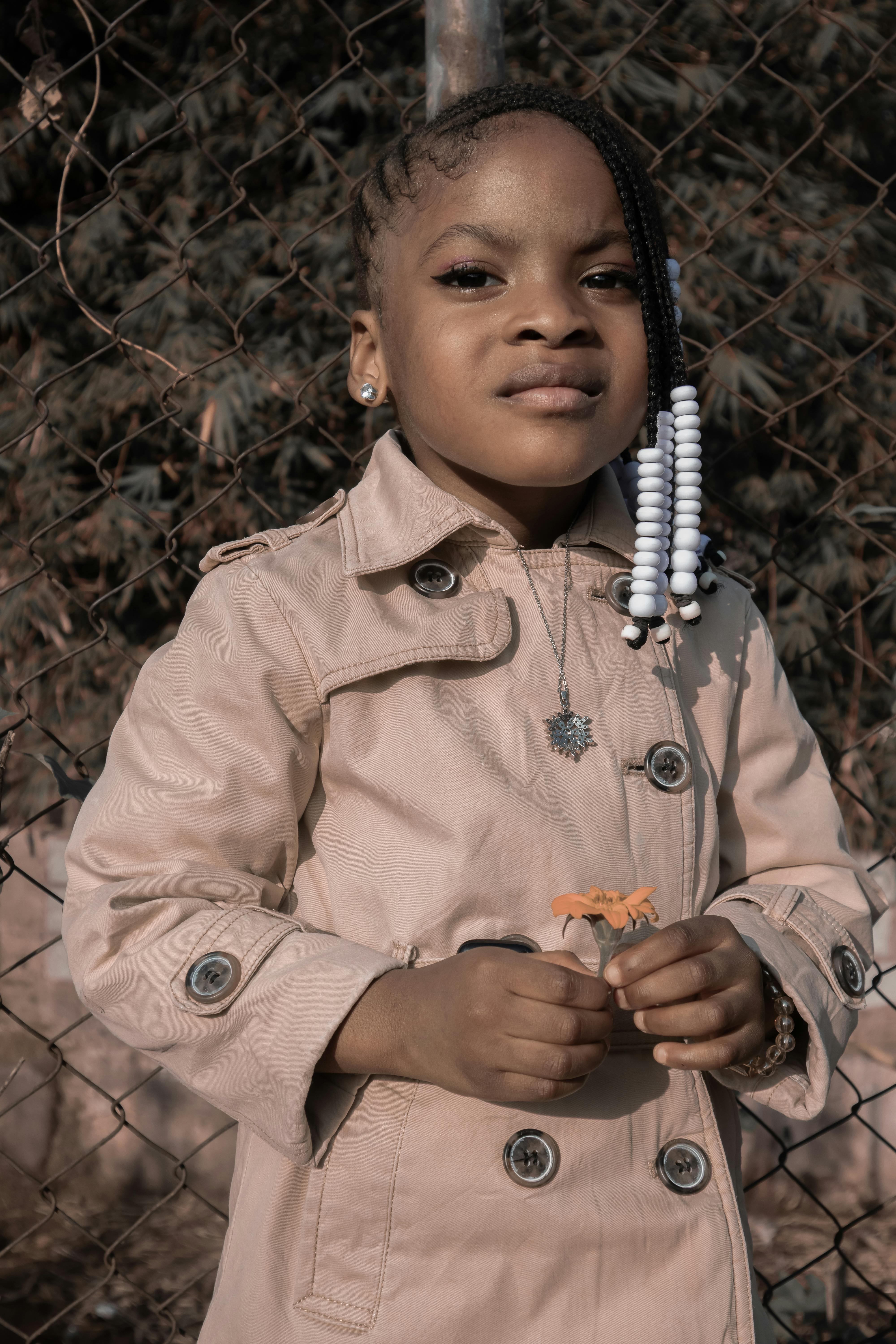 Young Girl in Trench Coat Holding Toy · Free Stock Photo