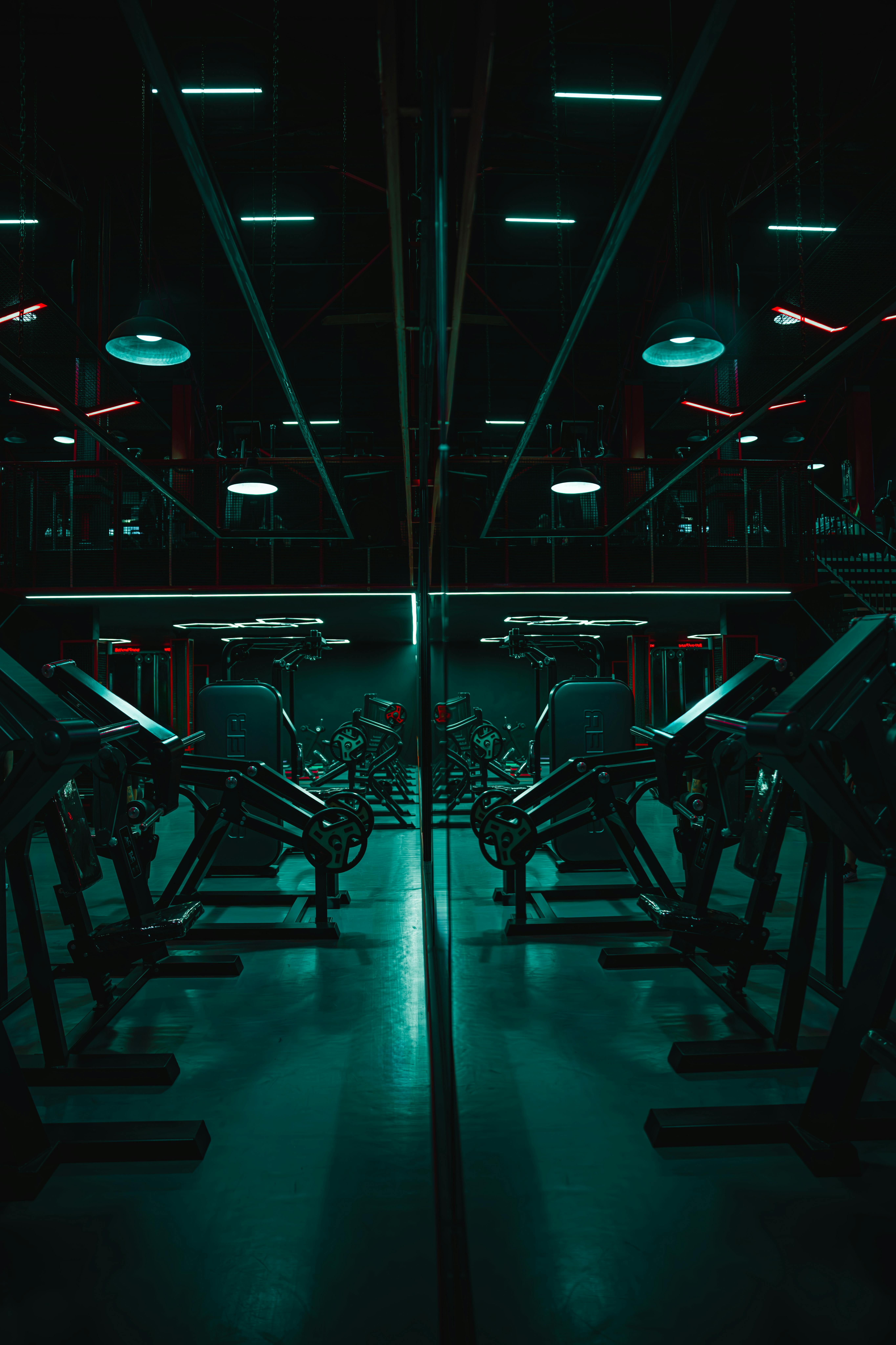 Dimly Lit Modern Gym with Equipment Reflection · Free Stock Photo