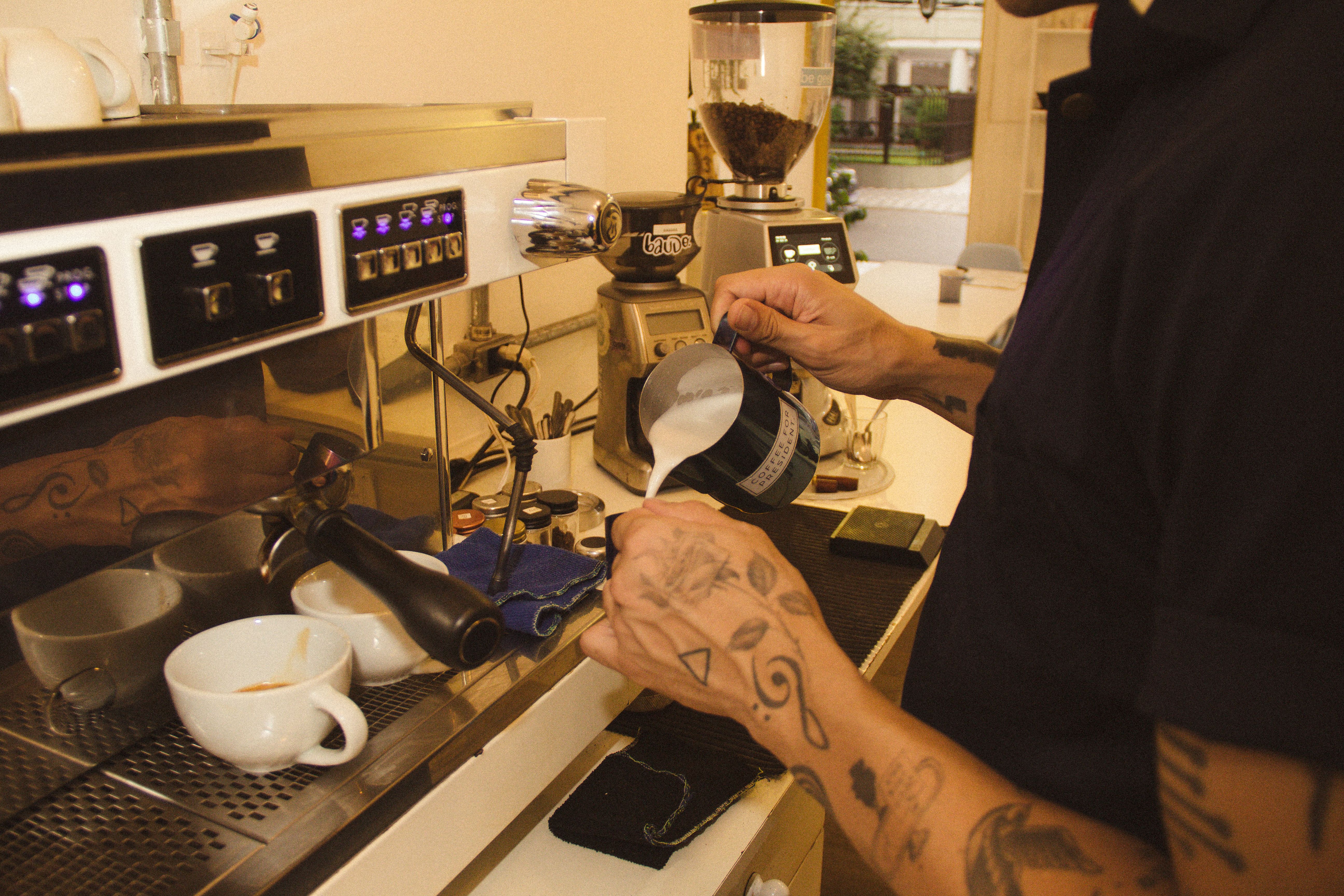 Barista Crafting a Perfect Latte in a Cozy Café · Free Stock Photo