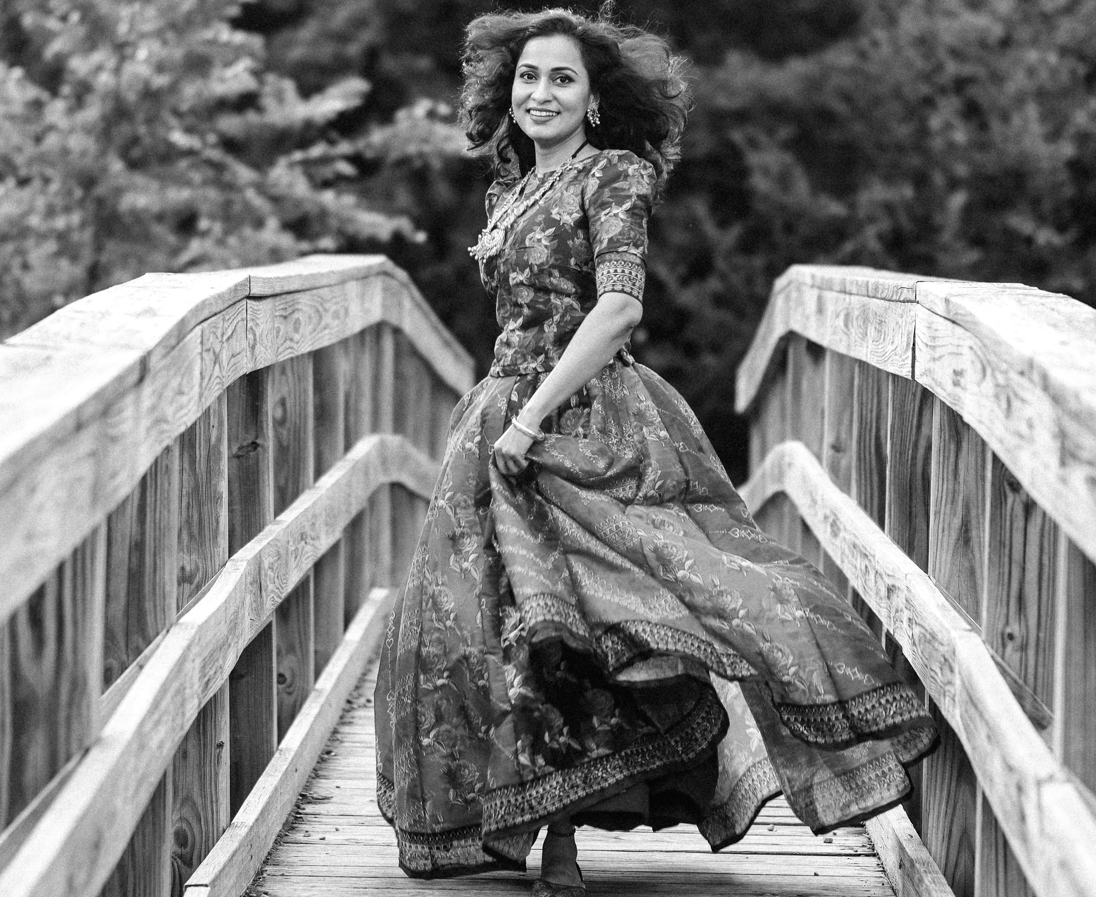 Elegant Woman in Flowing Dress on Wooden Bridge · Free Stock Photo