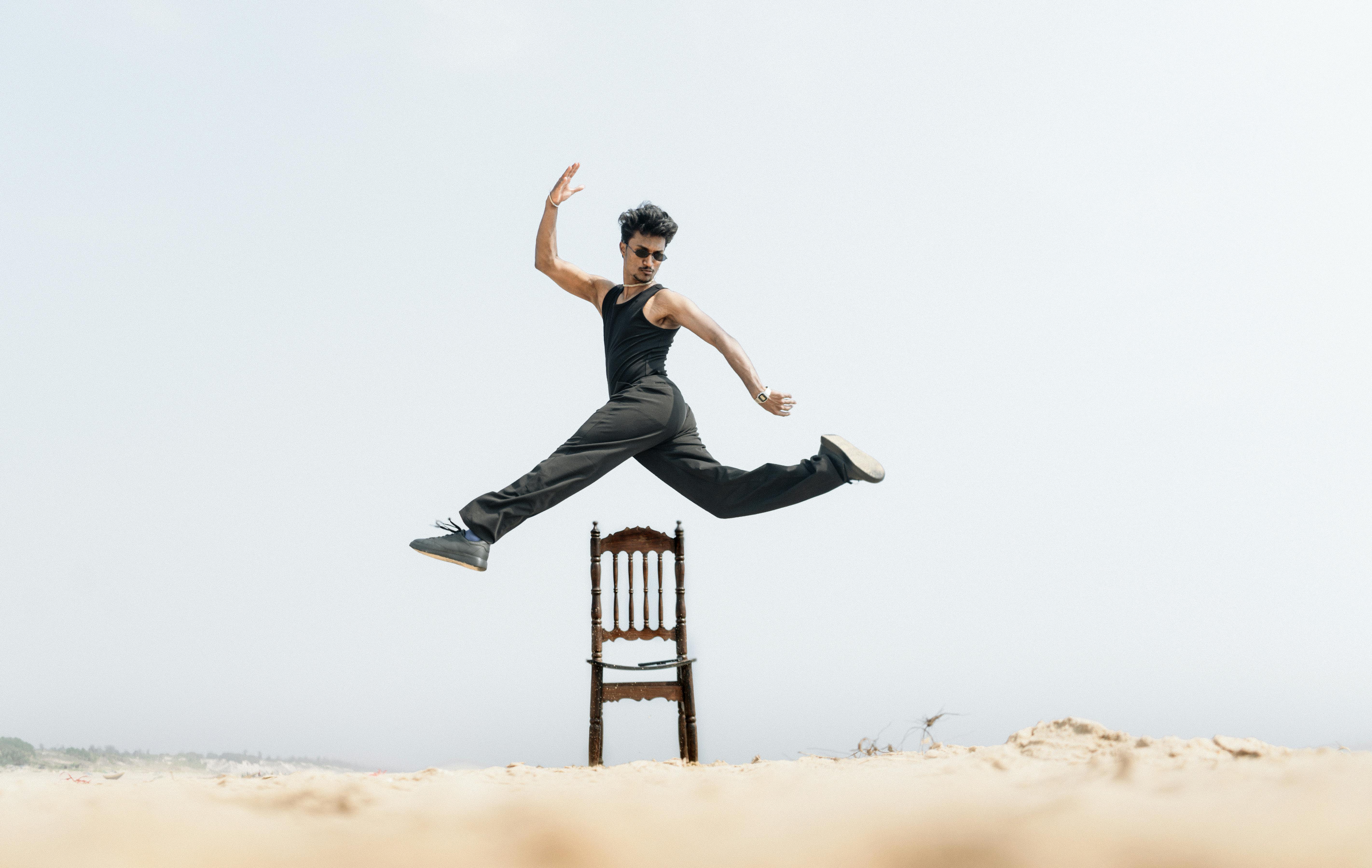 Dynamic Jumping Pose on Beach Sand · Free Stock Photo