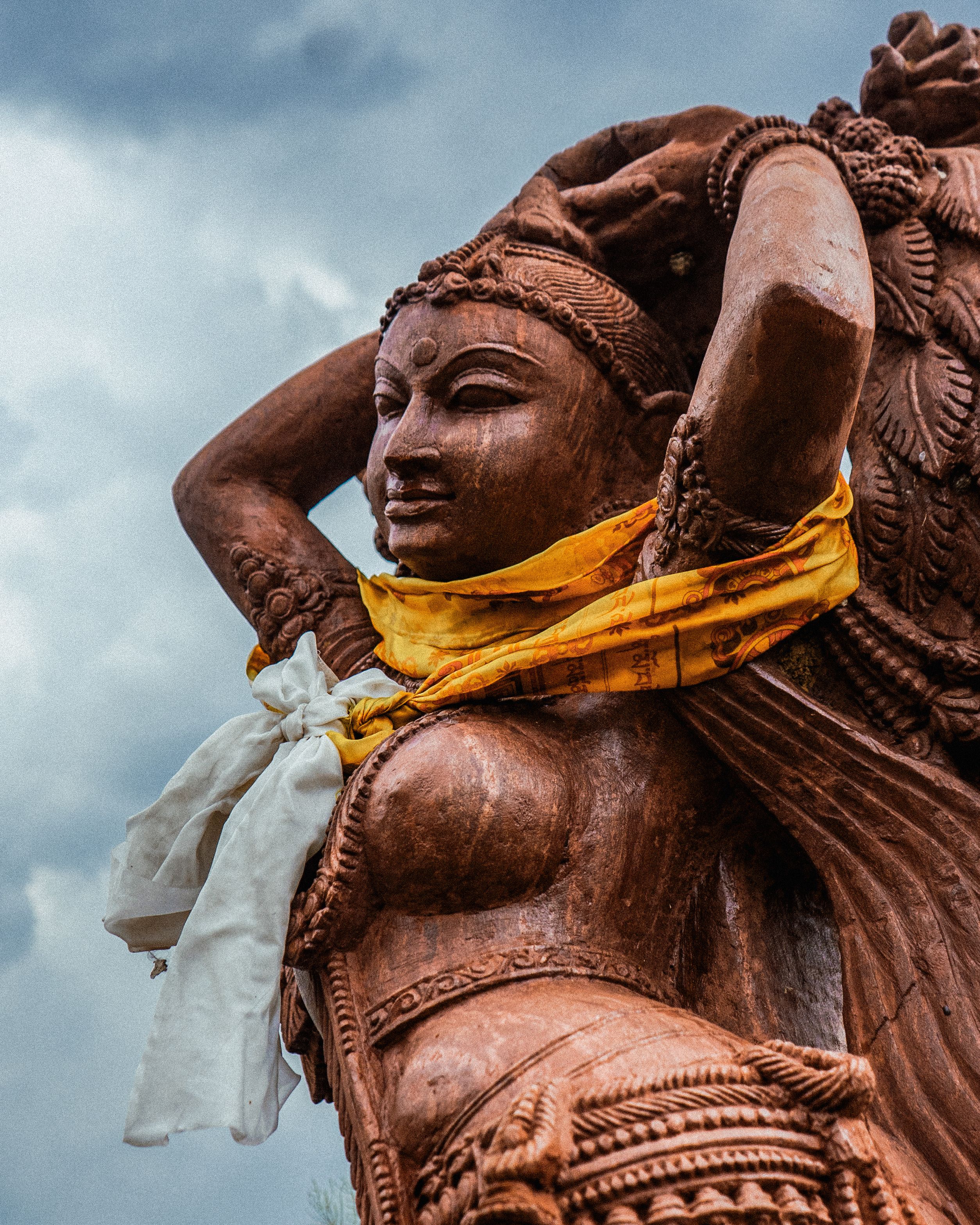 Ancient Stone Statue Draped in Colorful Cloth · Free Stock Photo