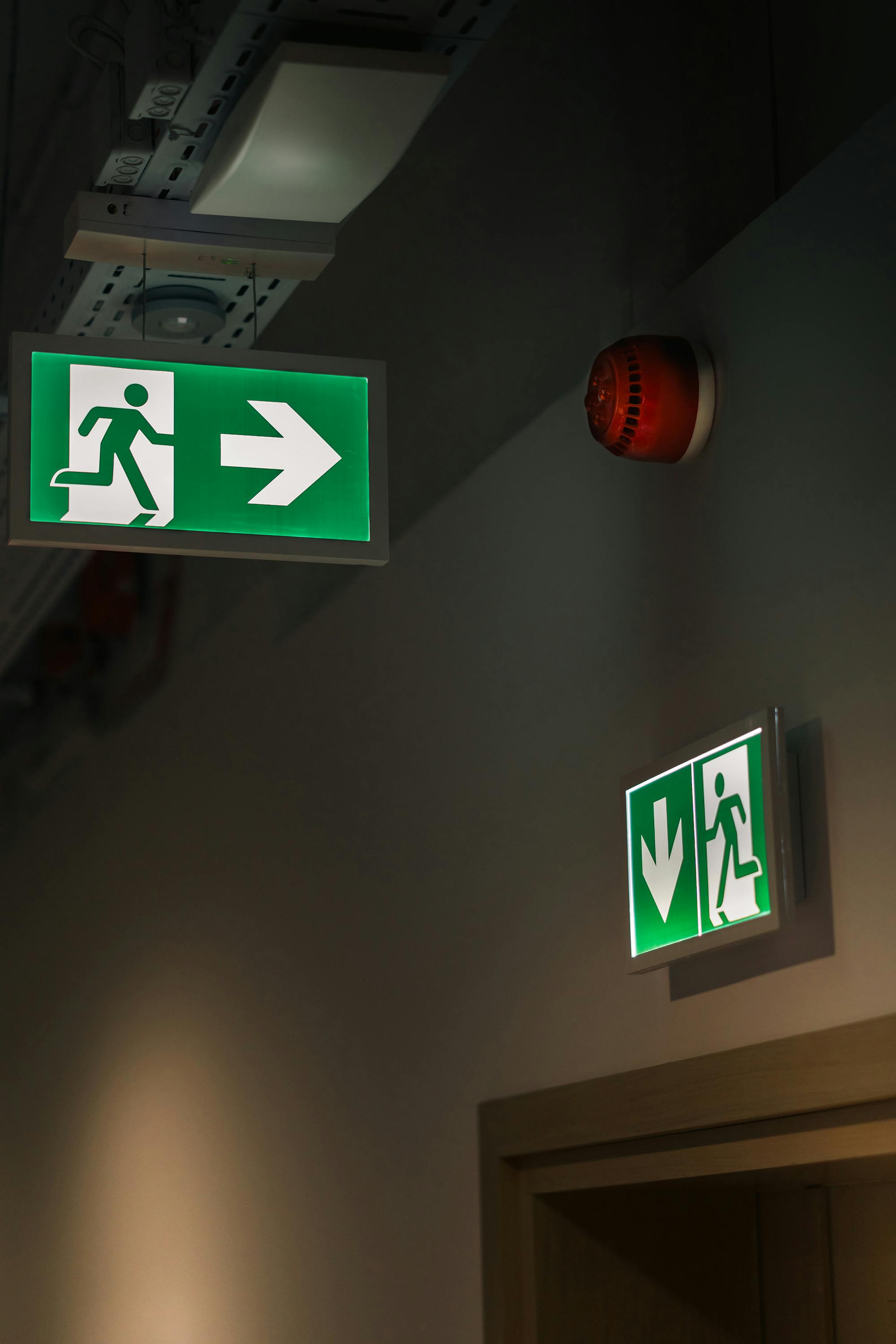 Emergency Exit Signs in a Building Hallway · Free Stock Photo
