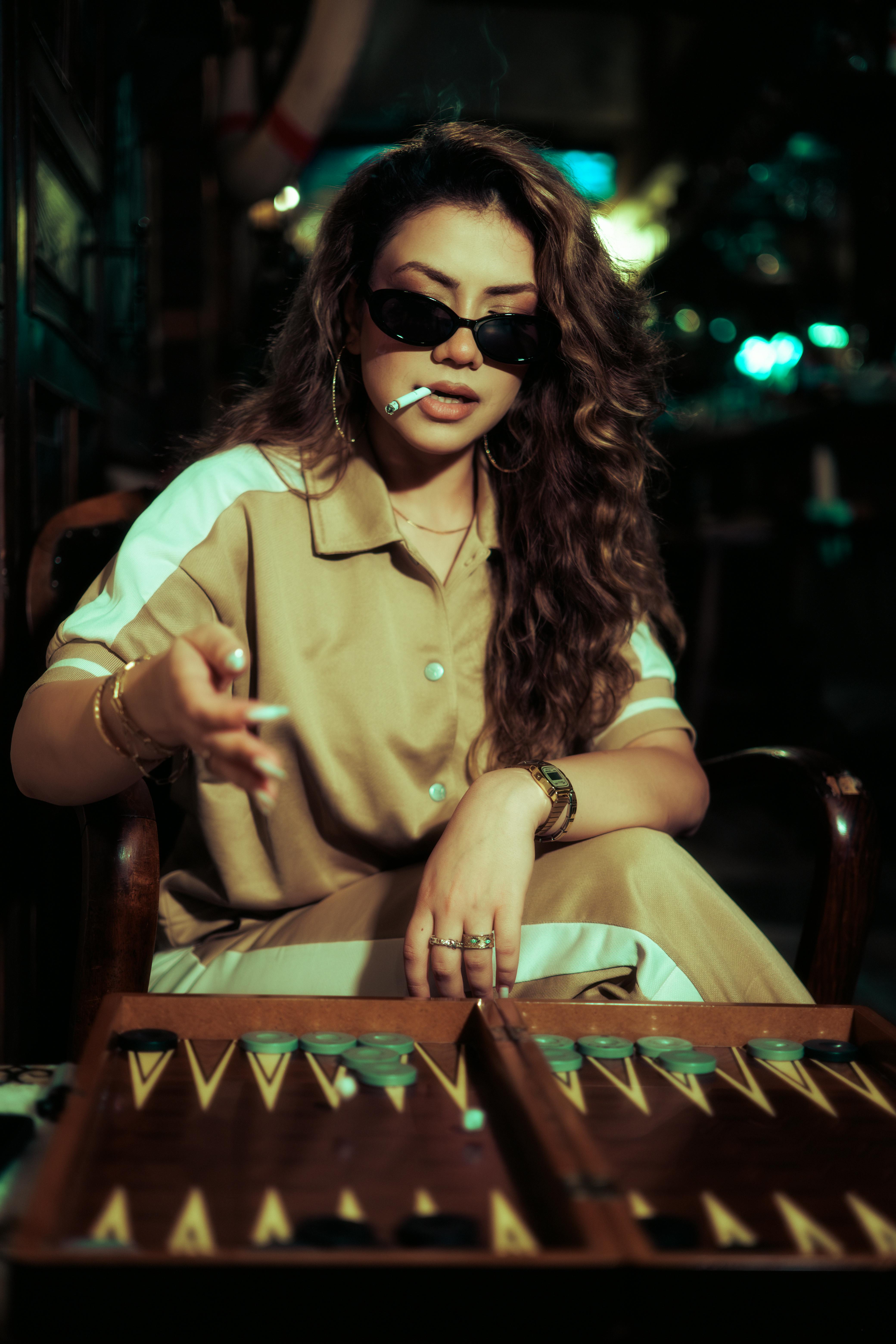 Stylish Woman Playing Backgammon Indoors with Cigarette · Free Stock Photo