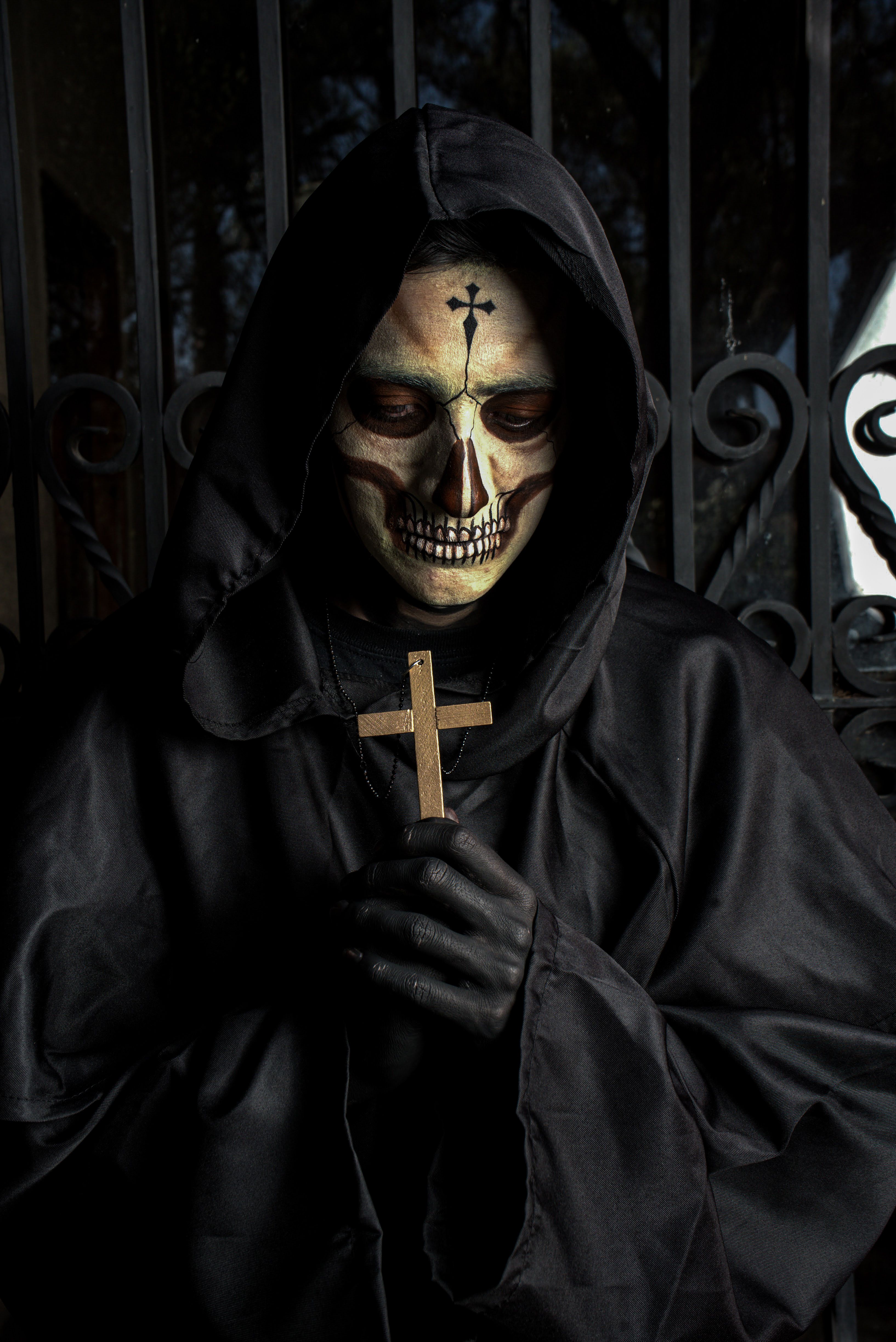 Creepy Hooded Figure with Cross in Dark Atmosphere · Free Stock Photo