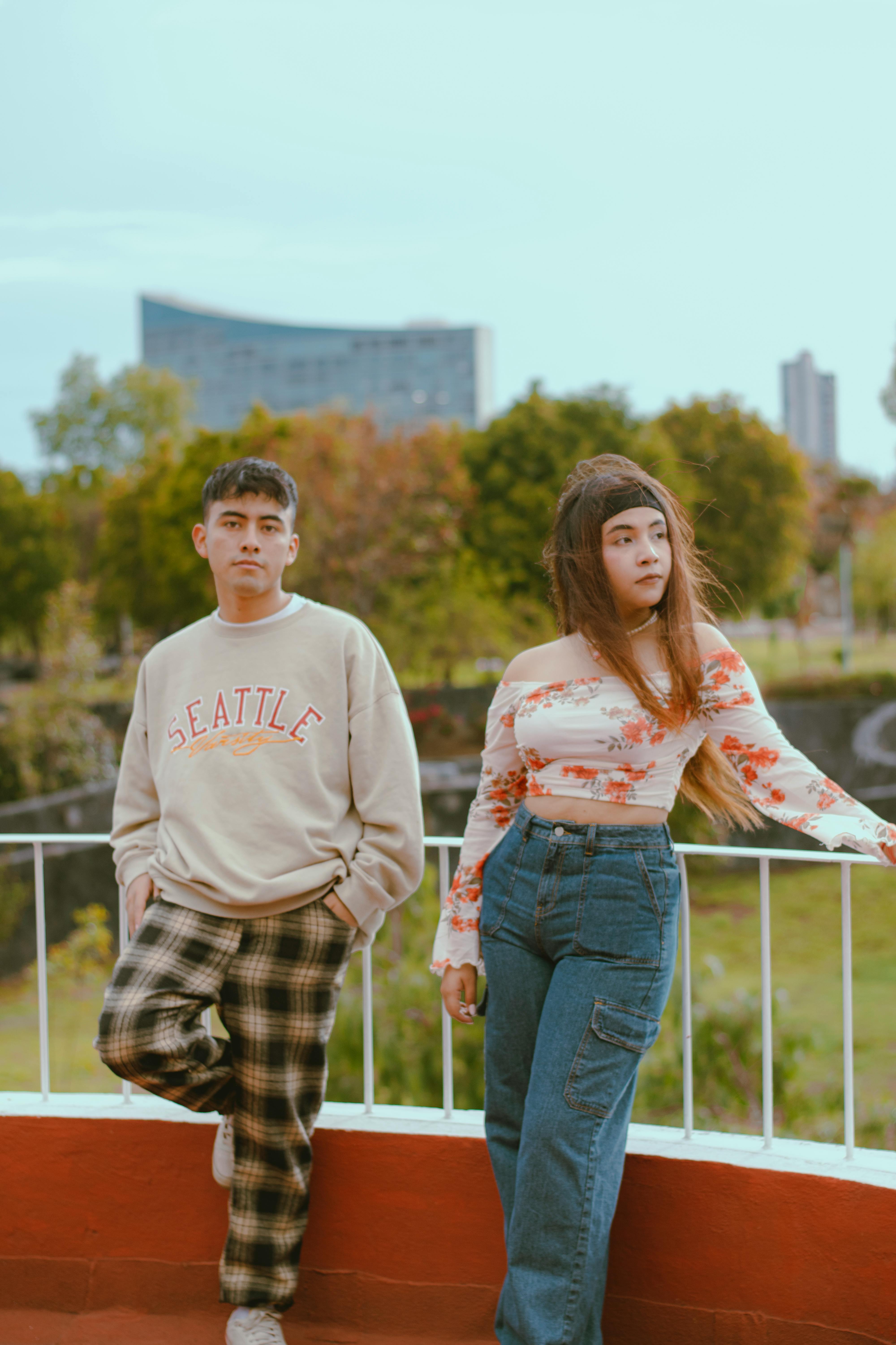 Young Adults Relaxing in Park with Urban Skyline · Free Stock Photo
