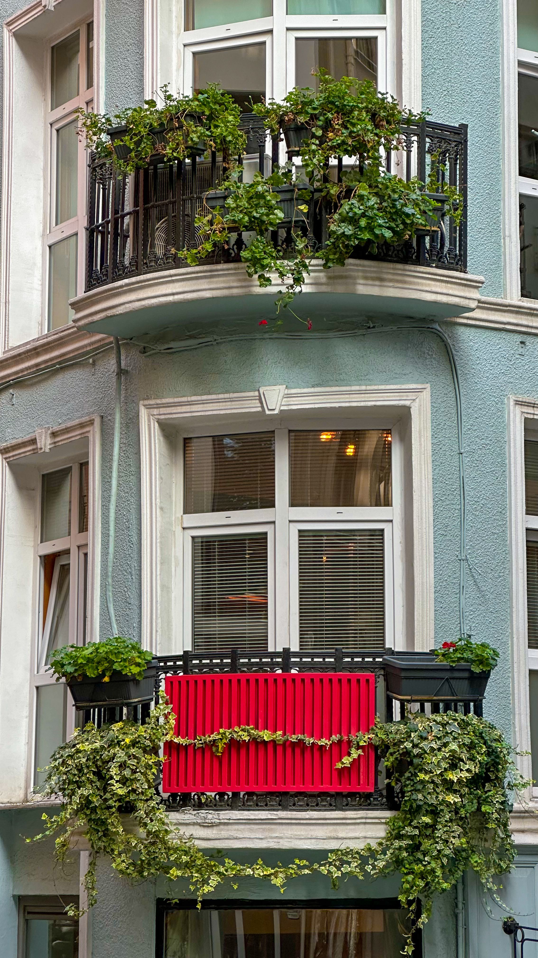 Charming Balcony with Lush Greenery and Red Accents · Free Stock Photo