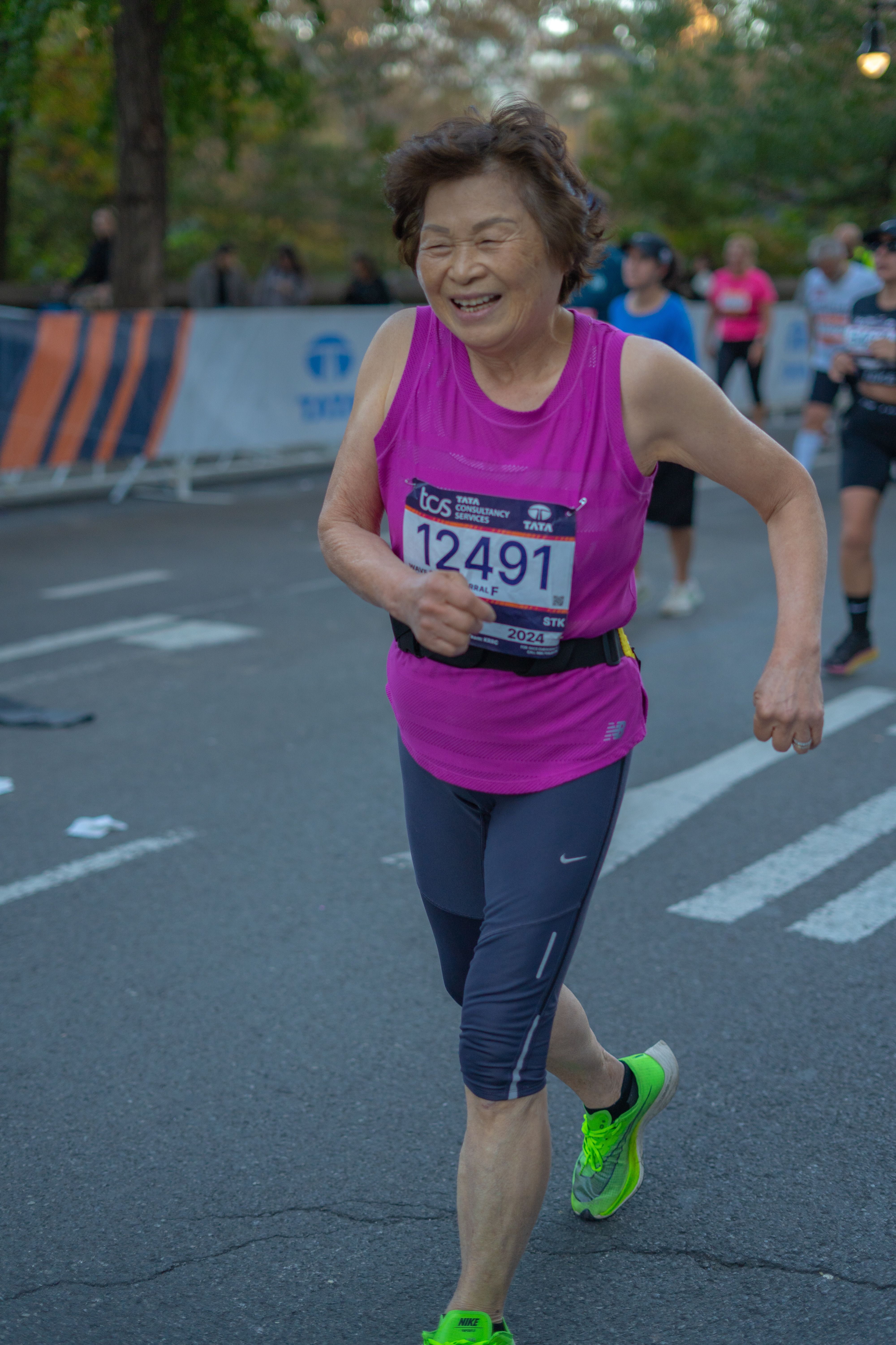 Elderly Woman Joyfully Running Marathon Race · Free Stock Photo