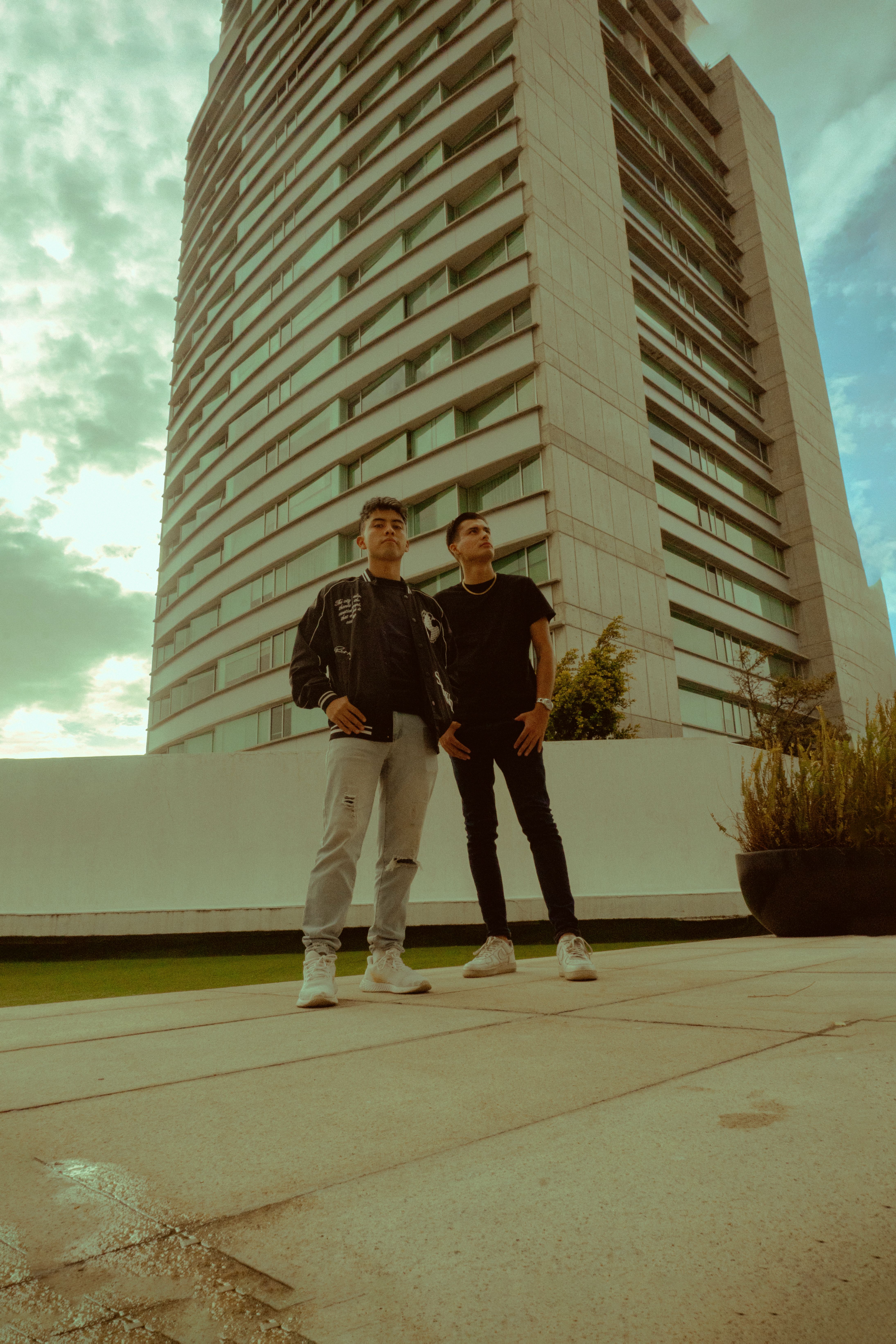 Two Men Standing in Front of Modern High-Rise Building · Free Stock Photo