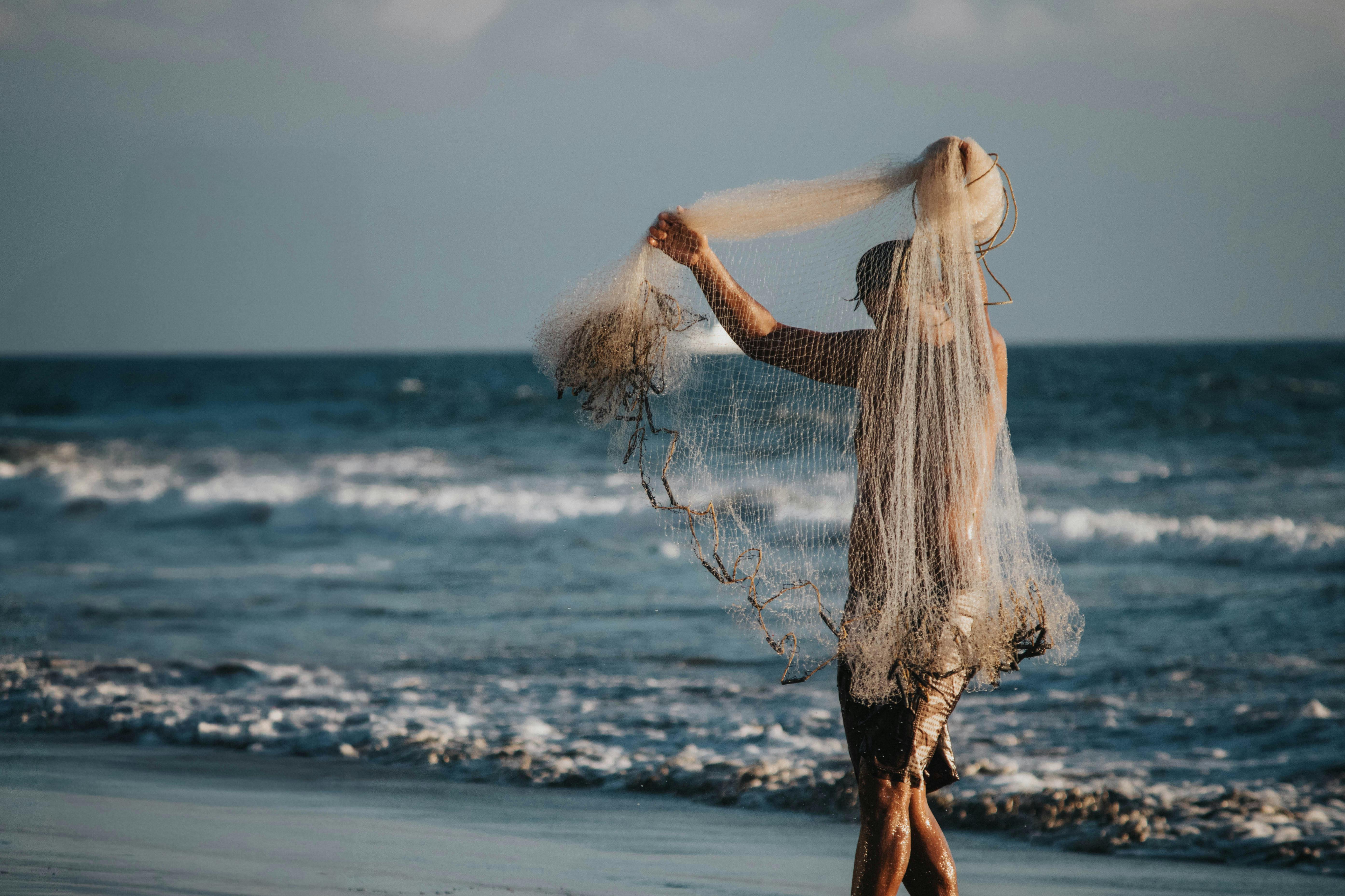 Fisherman Casting Net on Tropical Beach · Free Stock Photo