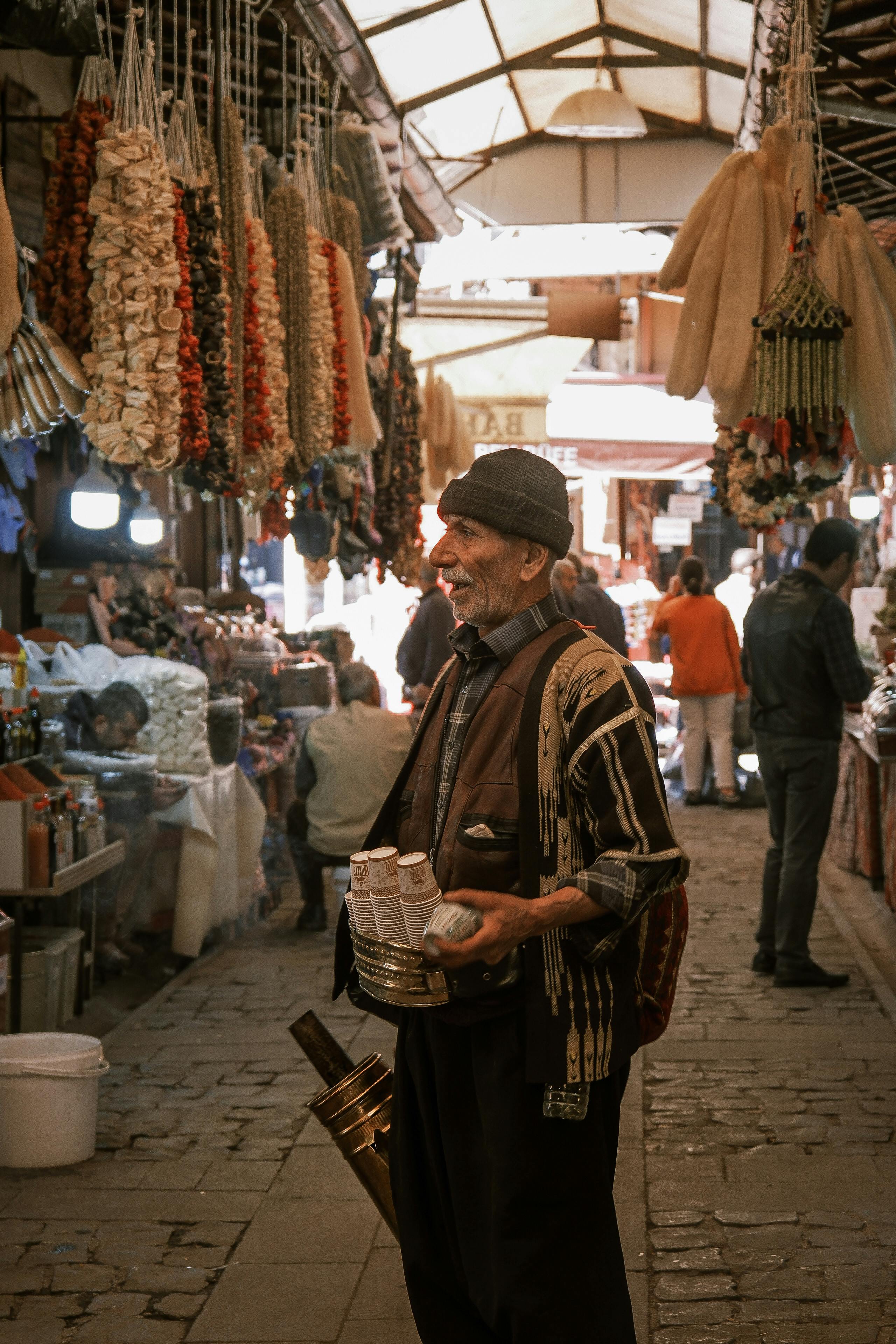 Cultural Market Scene with Vendor and Hanging Goods · Free Stock Photo