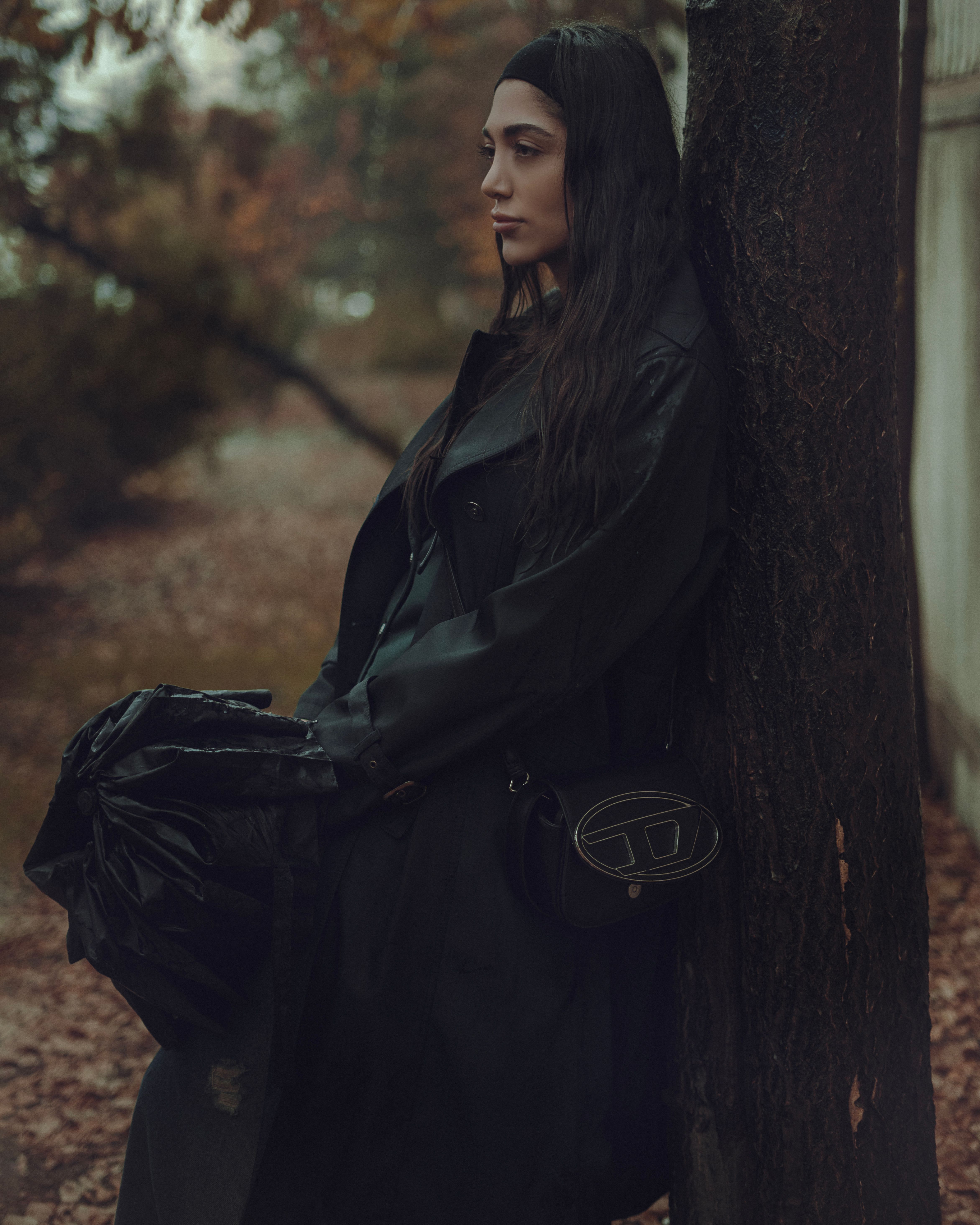 Contemplative Woman Leaning Against Tree in Autumn · Free Stock Photo
