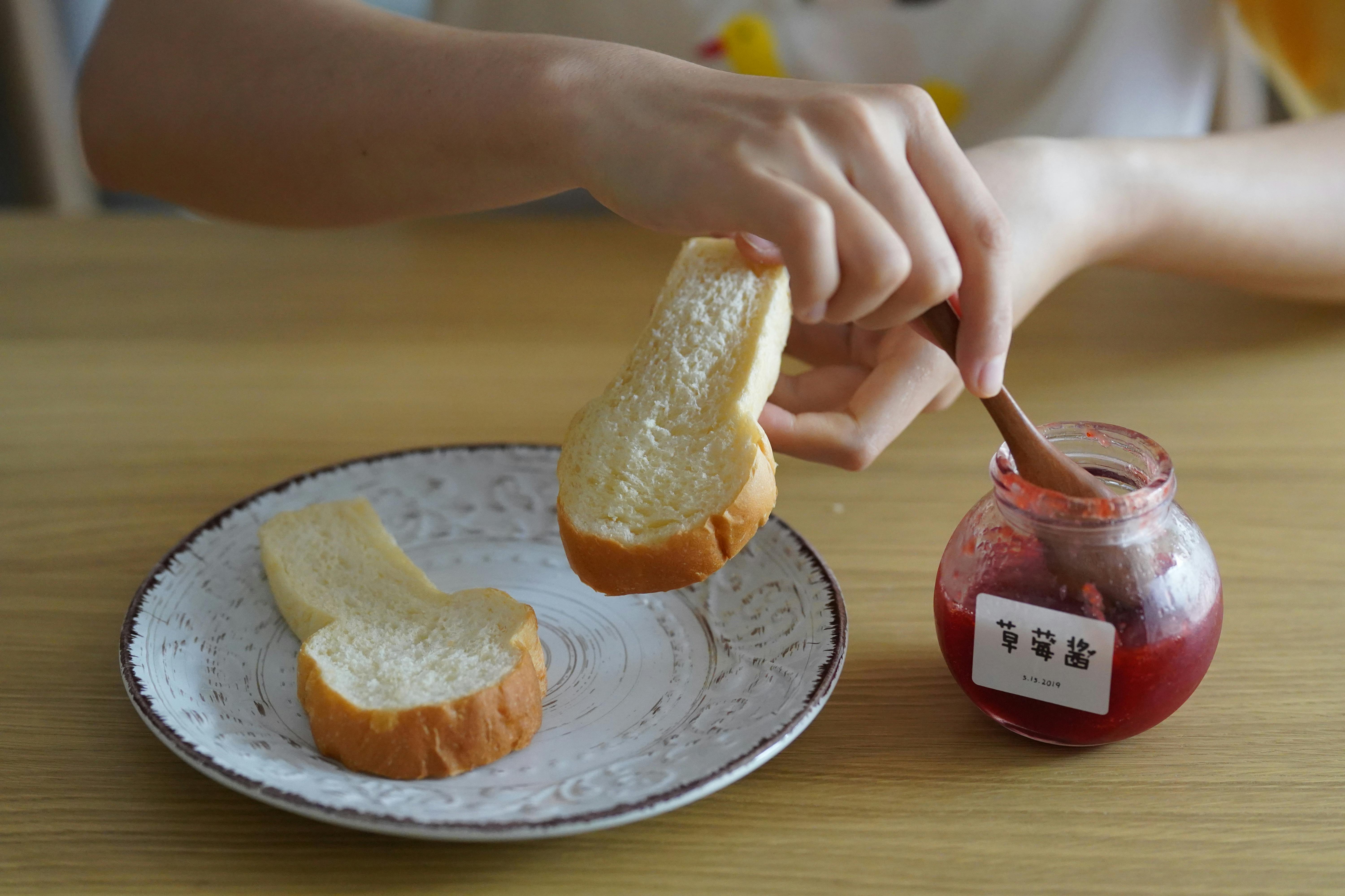A Close-Up Shot of a Person Eating Bread and Jam · Free Stock Photo