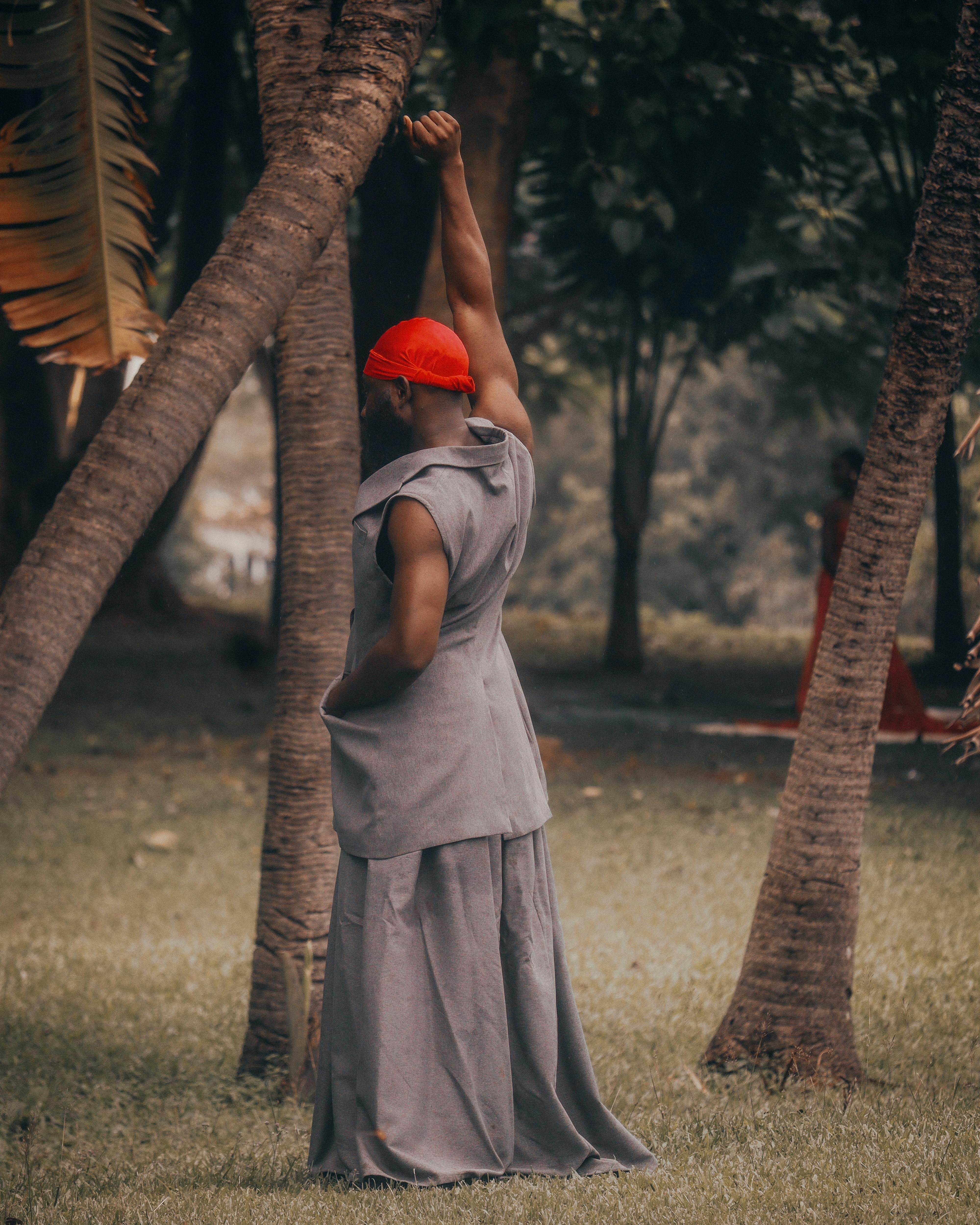 Hombre Con Traje Tradicional Bajo Palmeras · Foto de stock gratuita
