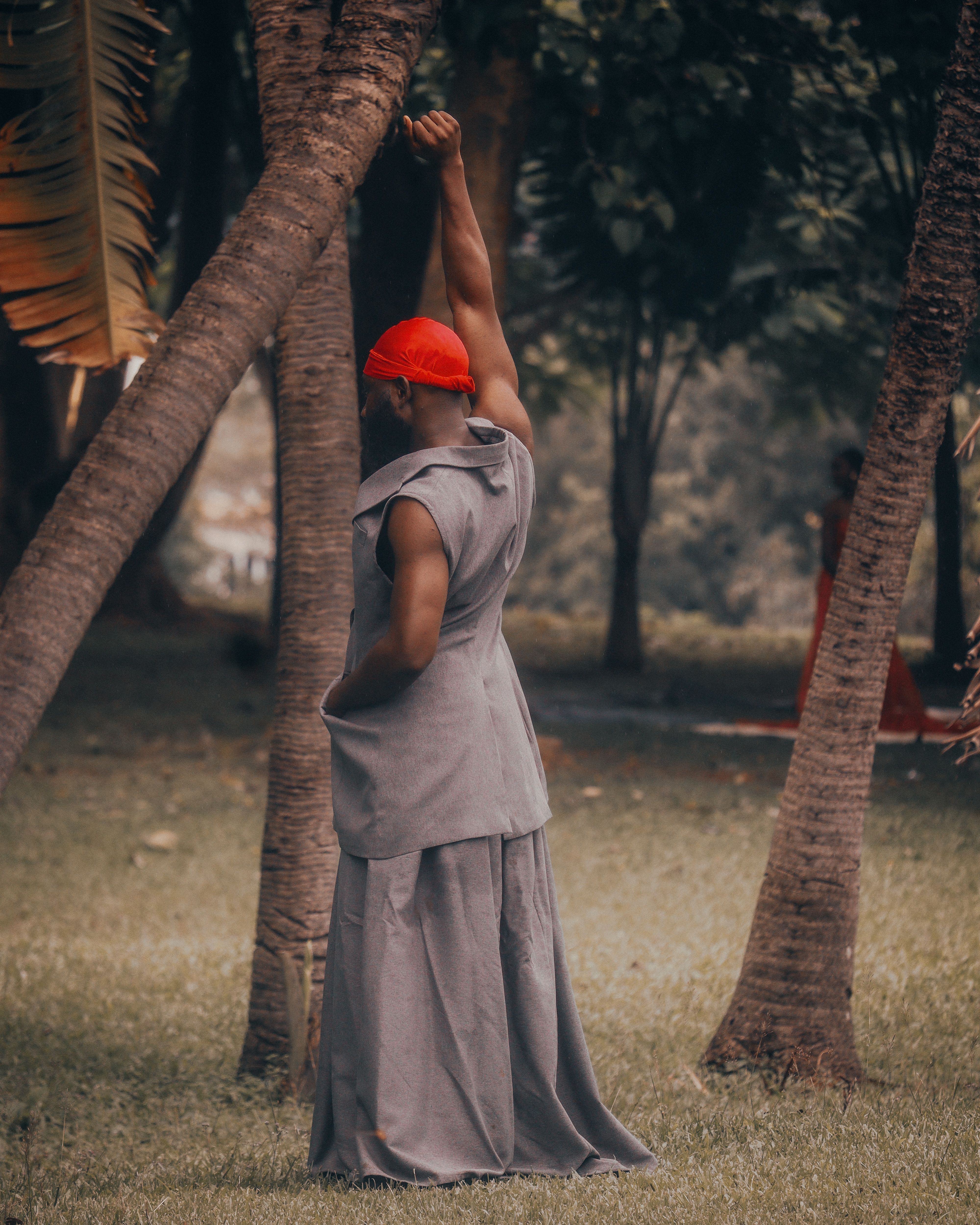 Man in Traditional Attire Under Palm Trees · Free Stock Photo