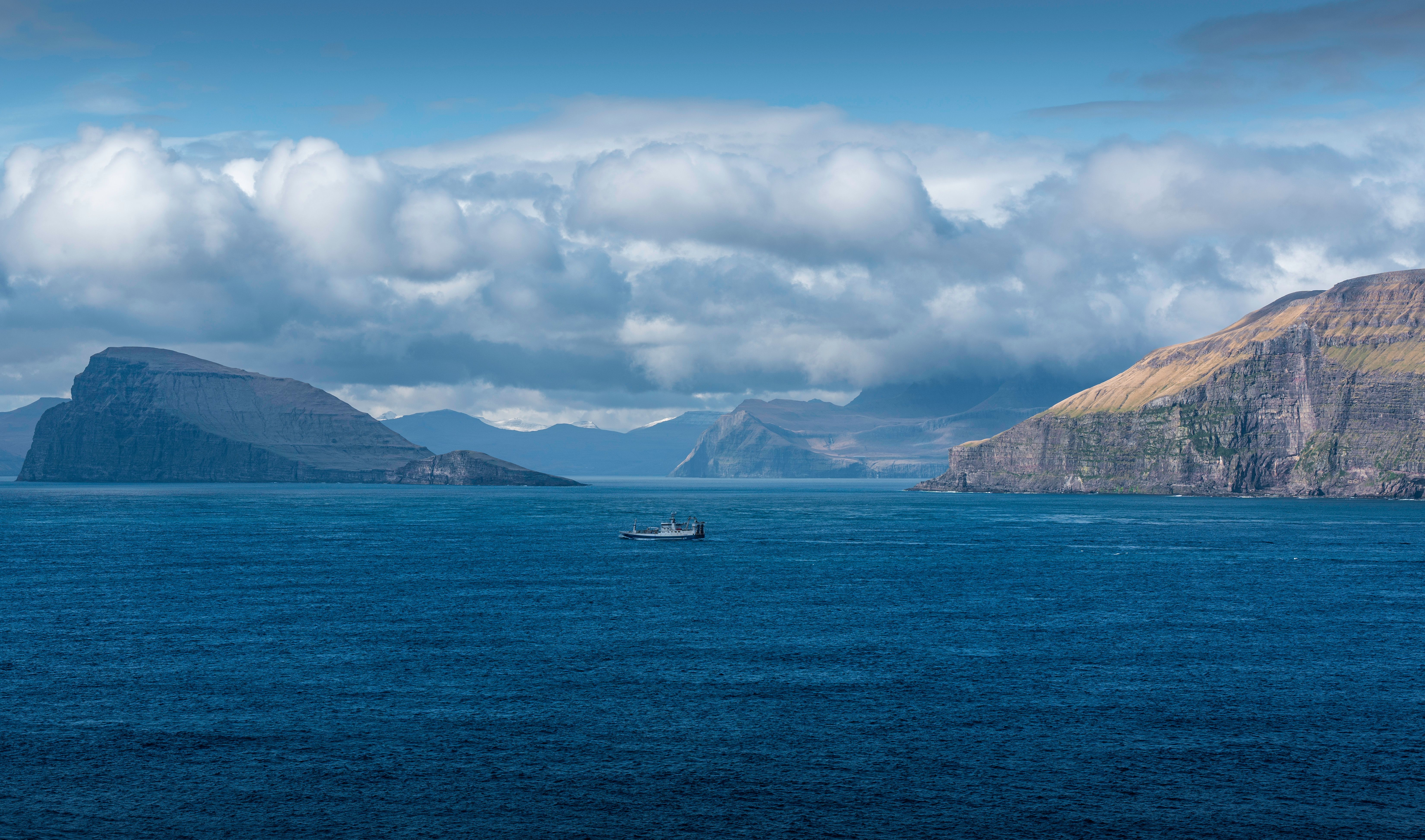 Dramatic Sea Cliffs and Fishing Boat in Faroe Islands · Free Stock Photo