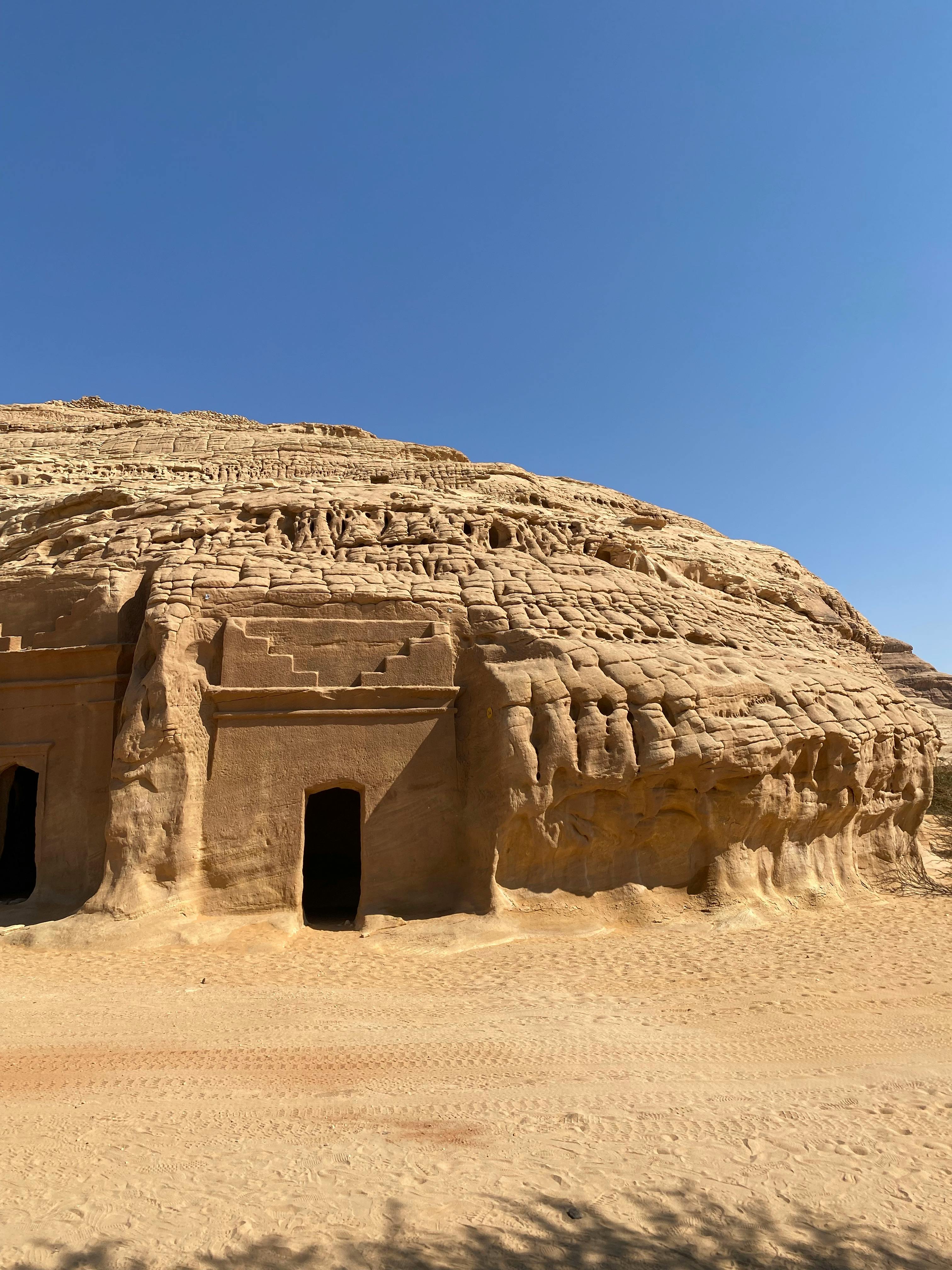 Ancient Rock Cut Tombs Under Clear Blue Sky · Free Stock Photo