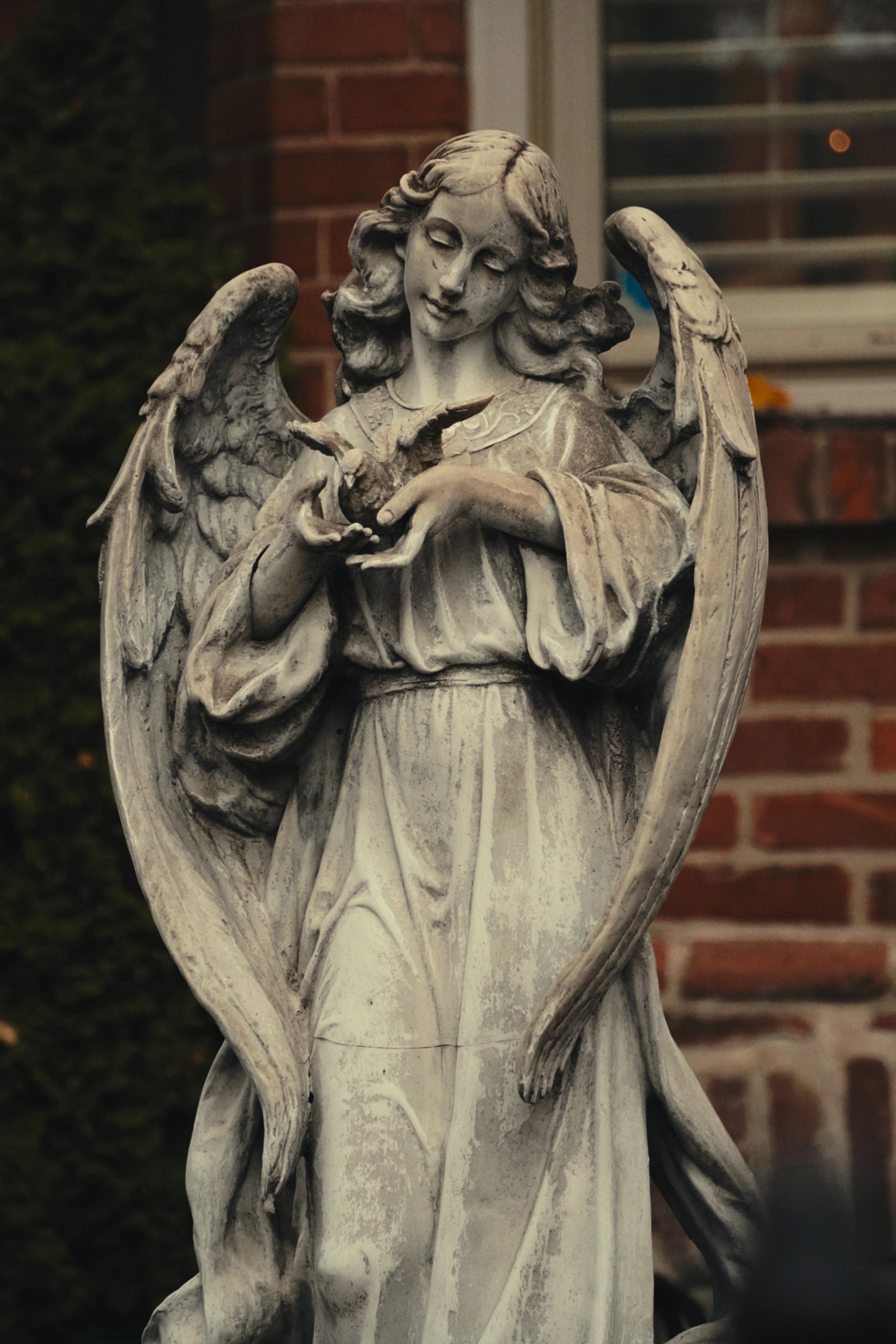 Vintage Angel Statue Against Brick Wall in Toronto · Free Stock Photo