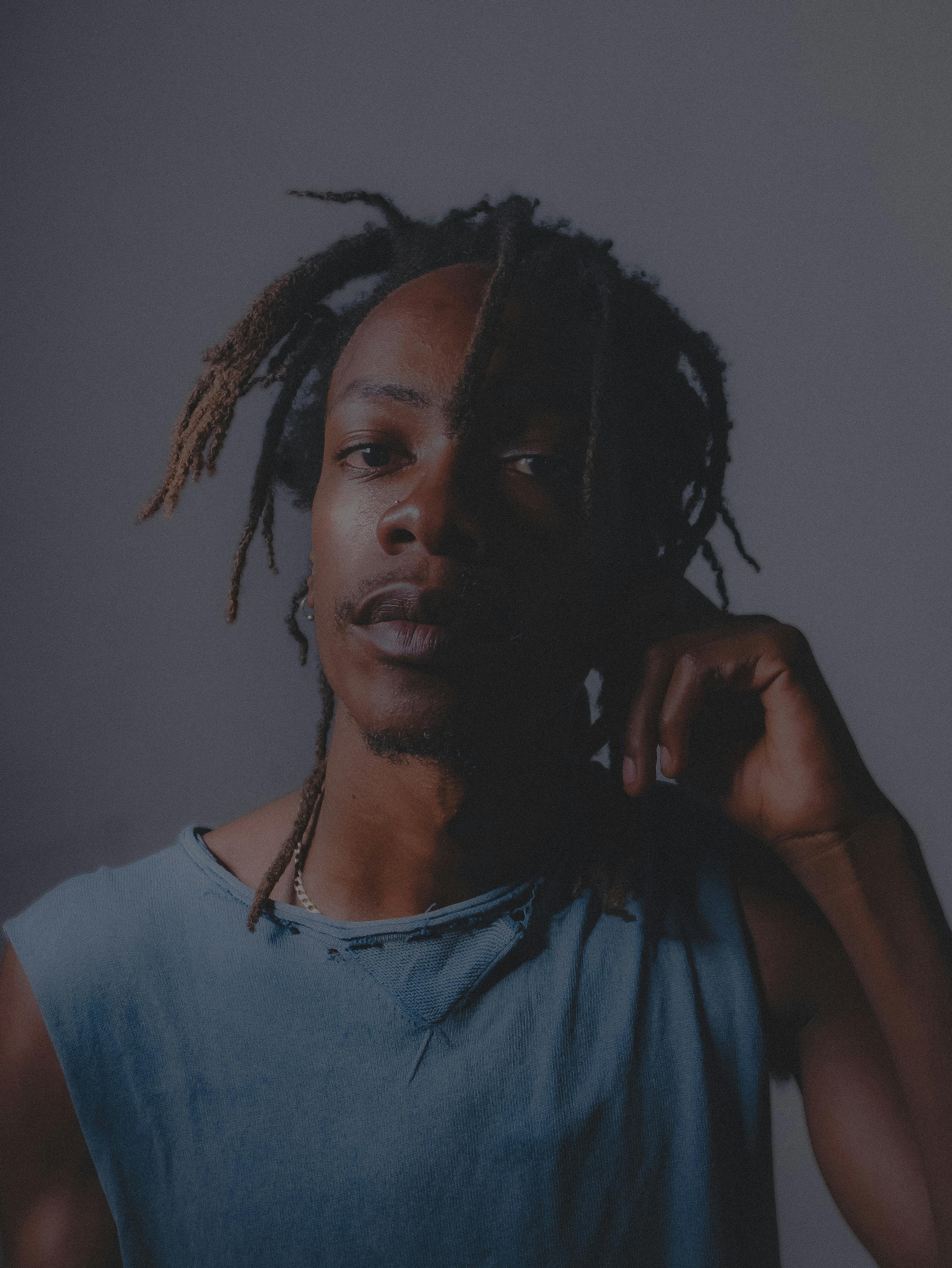 Portrait of a Man with Dreadlocks in Moody Lighting · Free Stock Photo
