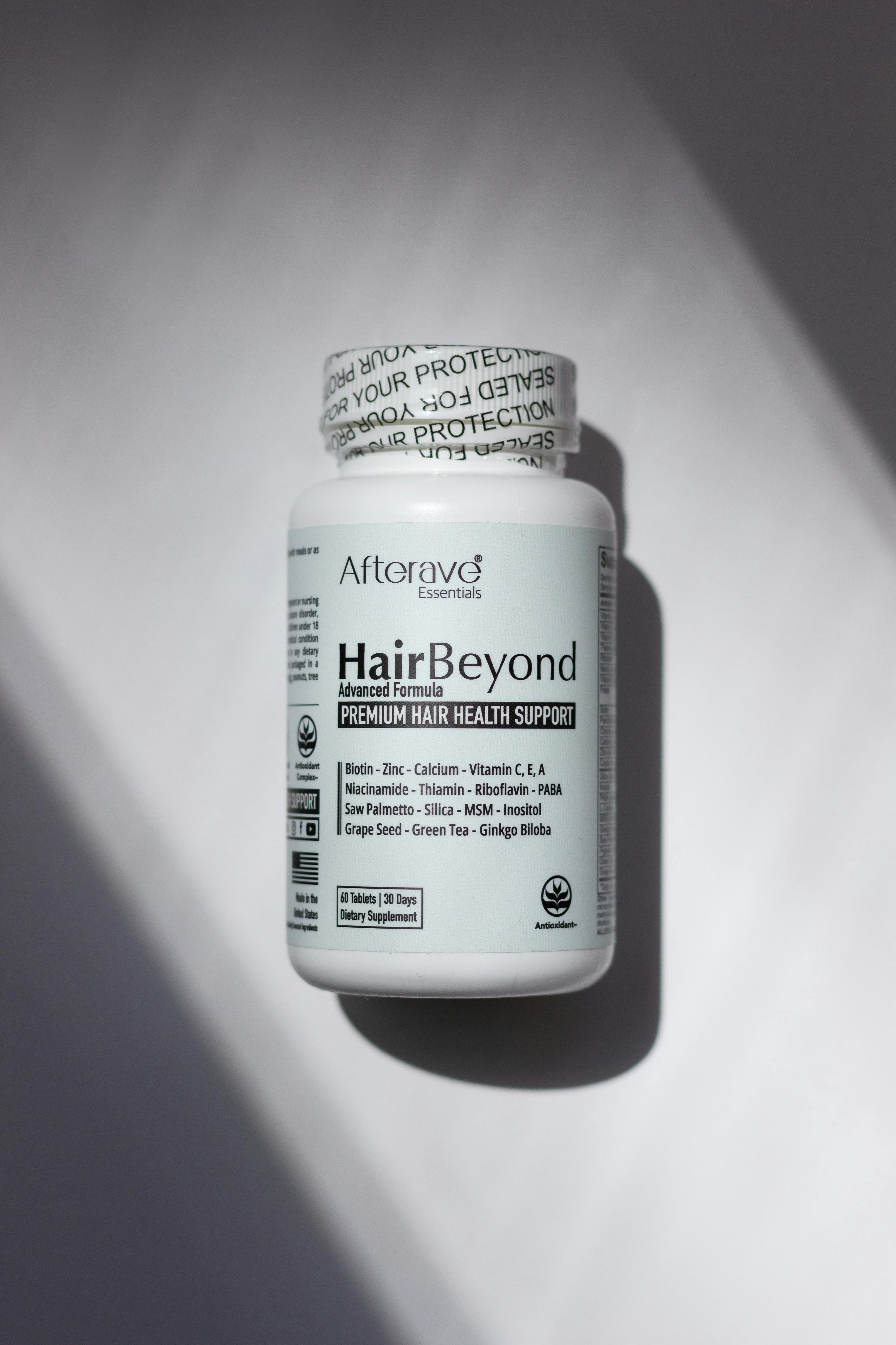 Premium Hair Health Supplement Bottle in Shadow · Free Stock Photo