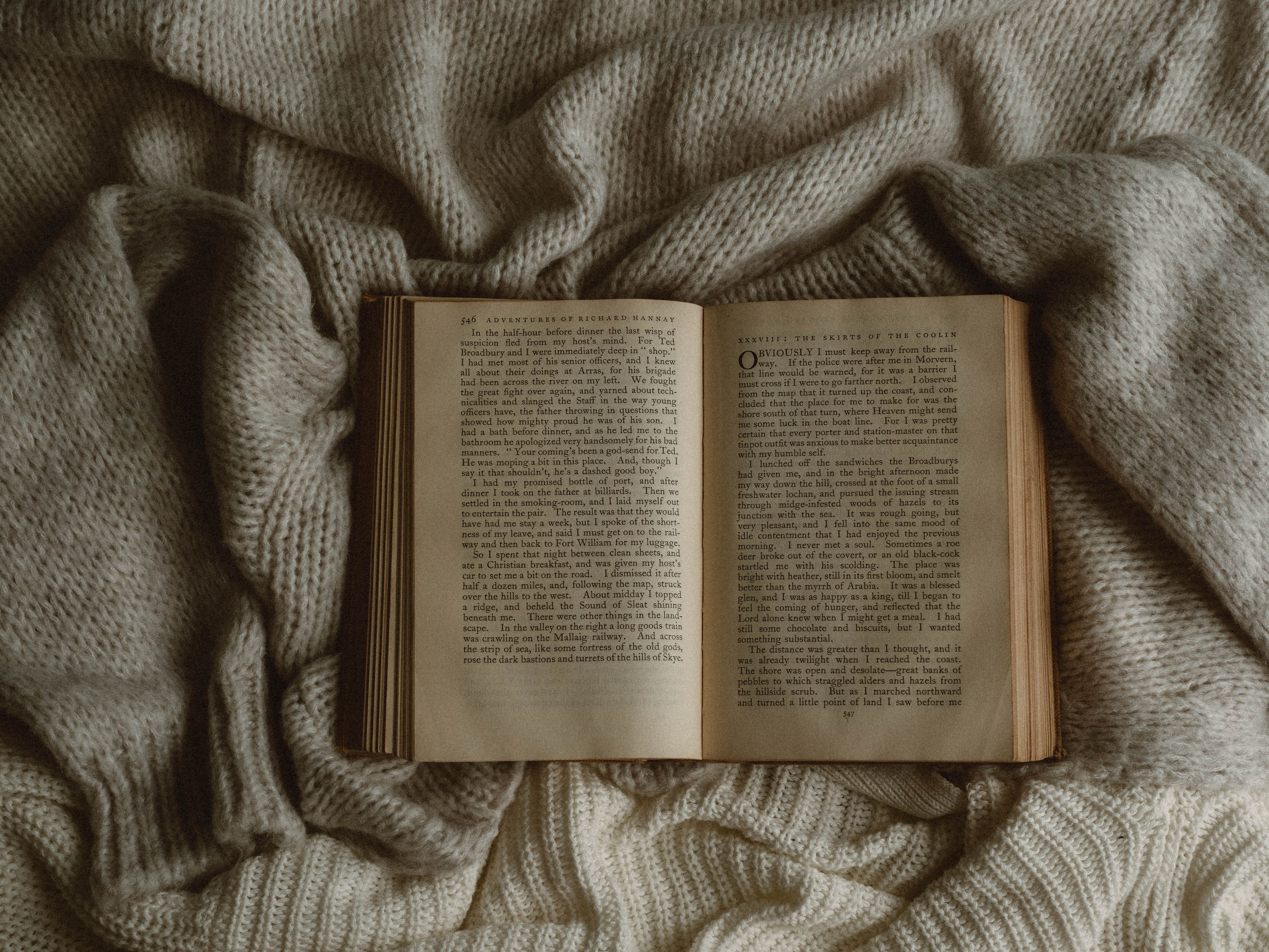 Vintage Book on Cozy Blanket in Warm Light · Free Stock Photo