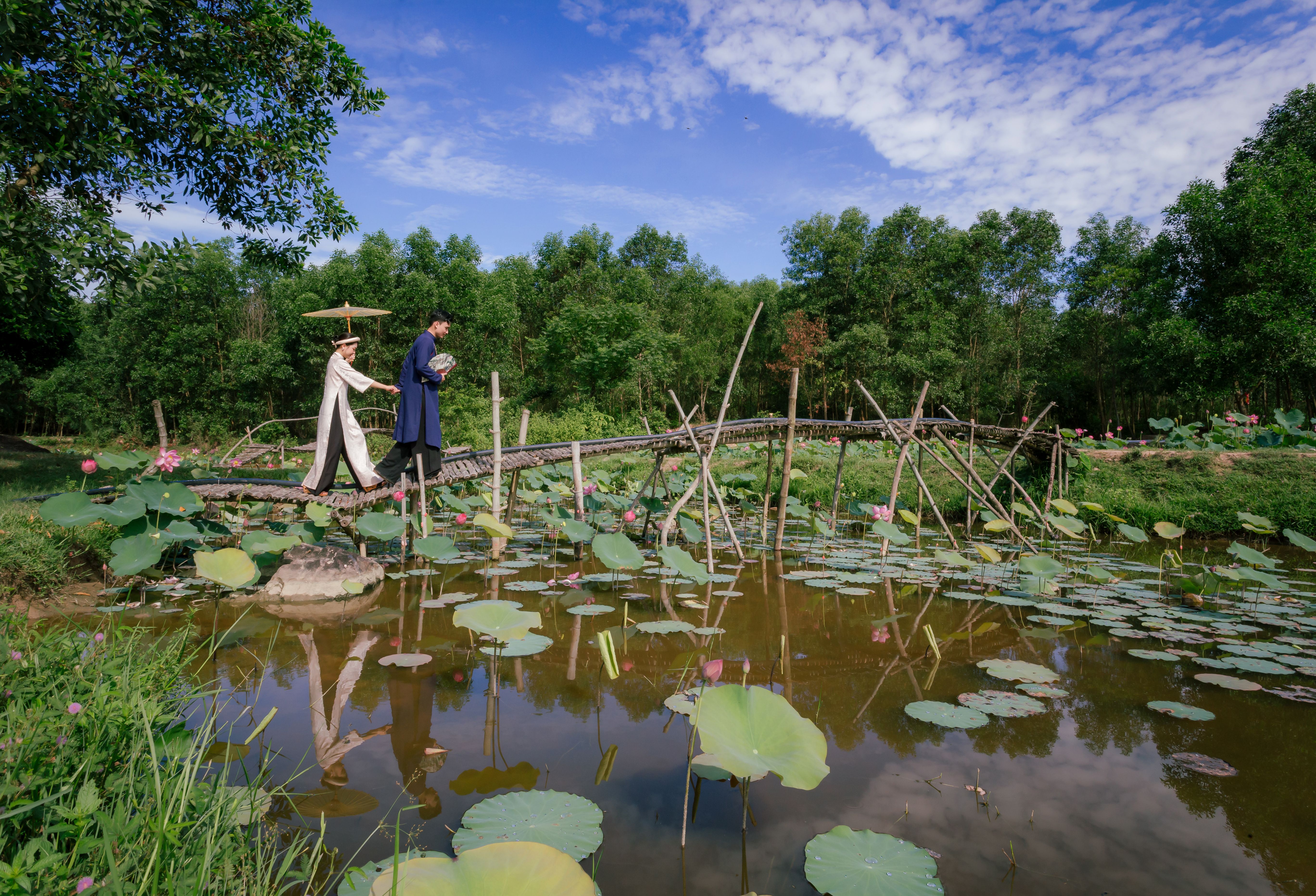 Traditional Vietnamese Couple Crossing Lotus Pond Bridge · Free Stock Photo