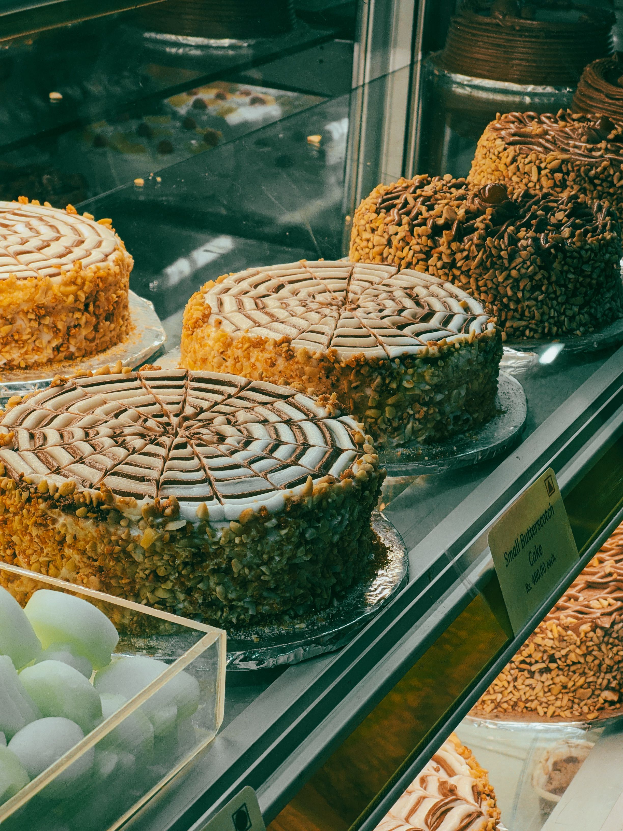 Delicious assortment of cakes in bakery display case · Free Stock Photo