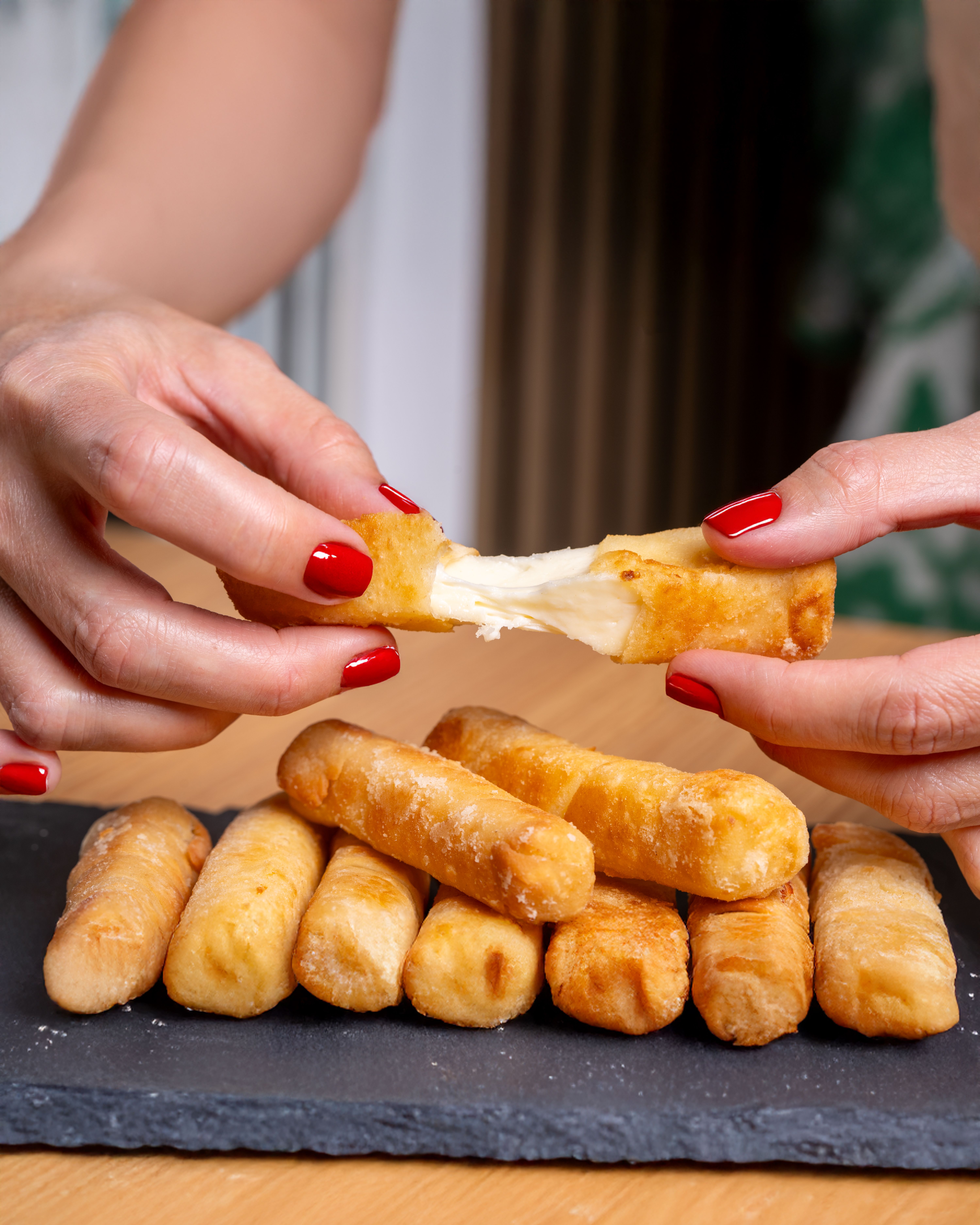 Woman Holding Cheese Sticks with Red Manicure · Free Stock Photo